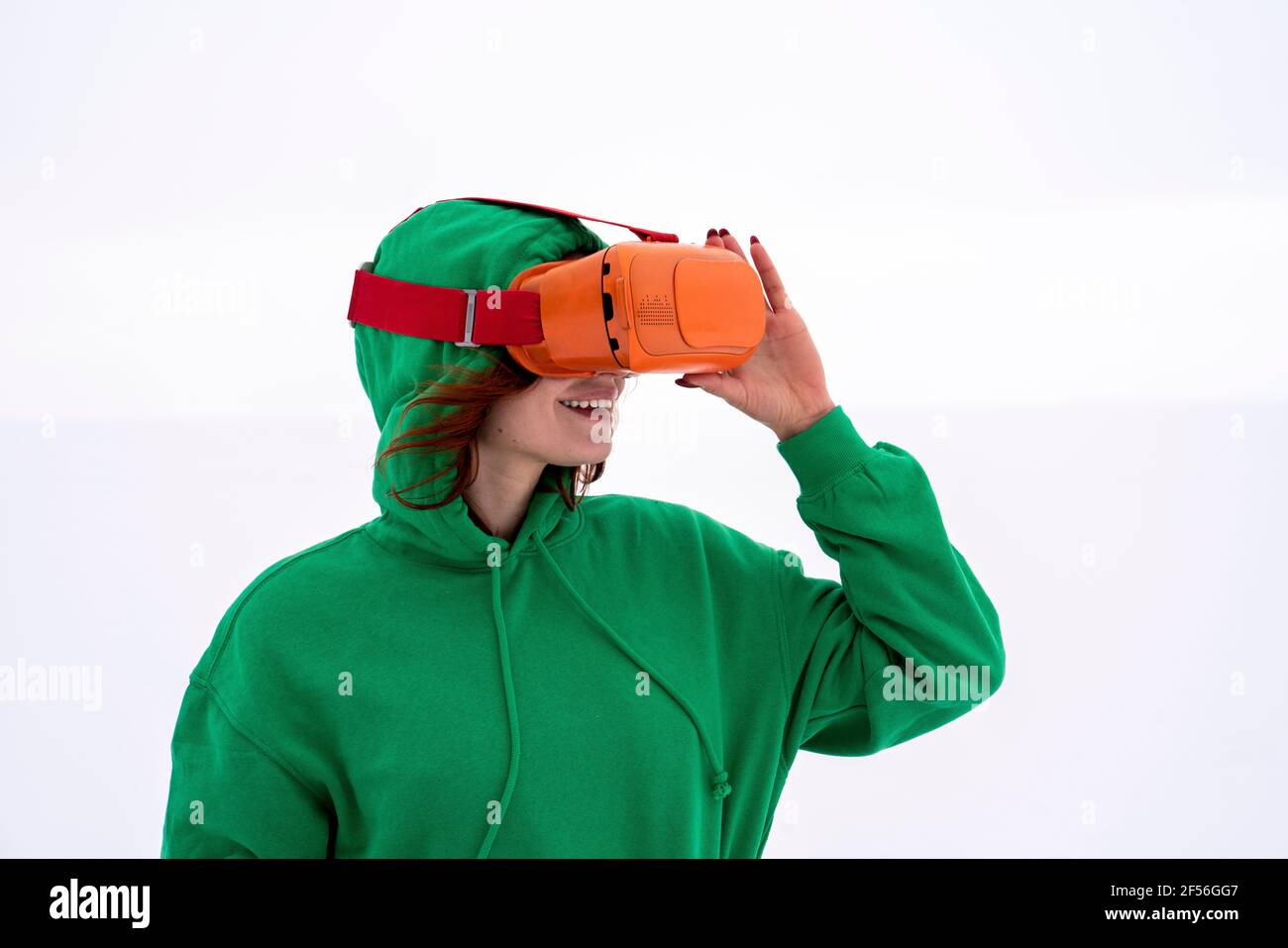 Smiling woman wearing costume using virtual reality simulator against ...