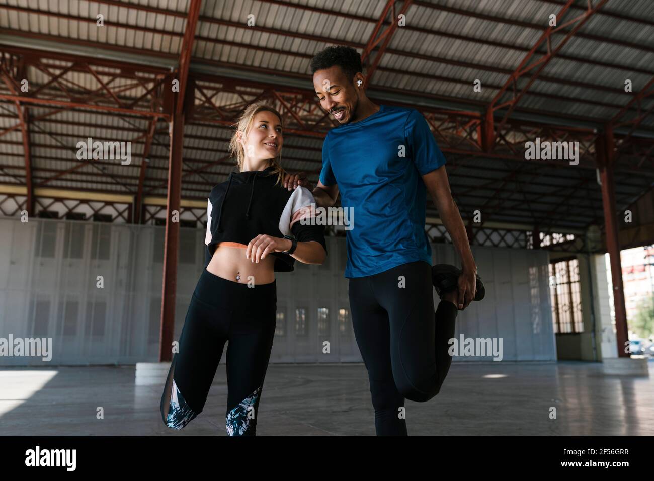 Male and female athletes doing warm up exercise in health club Stock ...