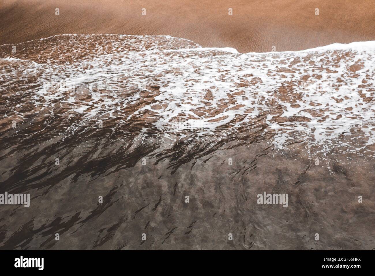 Vertical shot of the blue seawater and sandy shore Stock Photo - Alamy