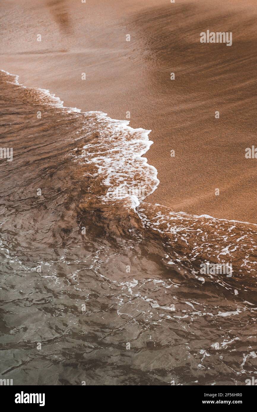Vertical shot of the blue seawater and sandy shore Stock Photo - Alamy