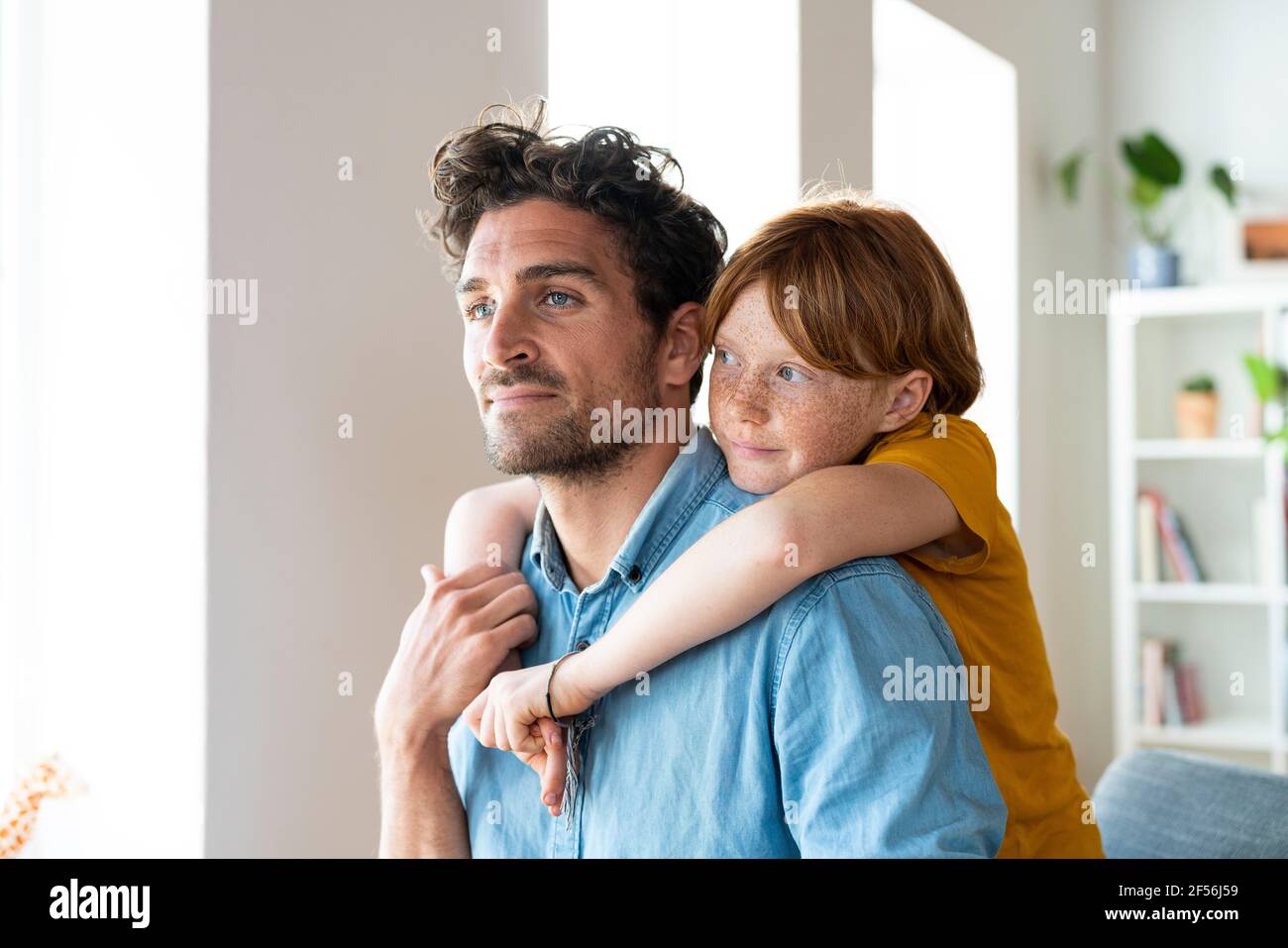 Redhead daughter cuddling father contemplating at home Stock Photo - Alamy