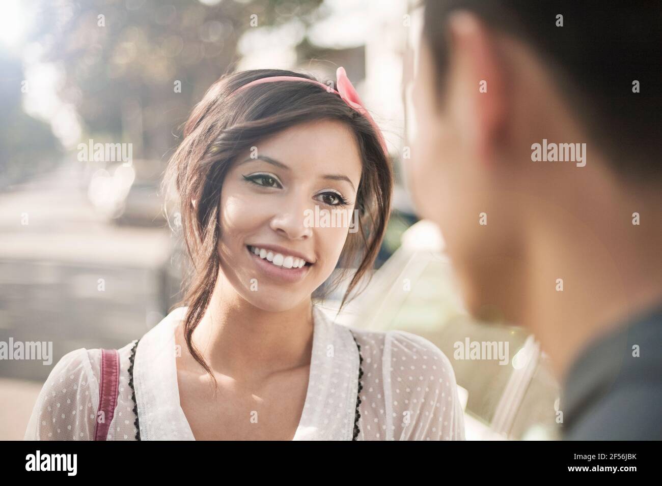 Girlfriend smiling while looking at boyfriend on sunny day Stock Photo ...