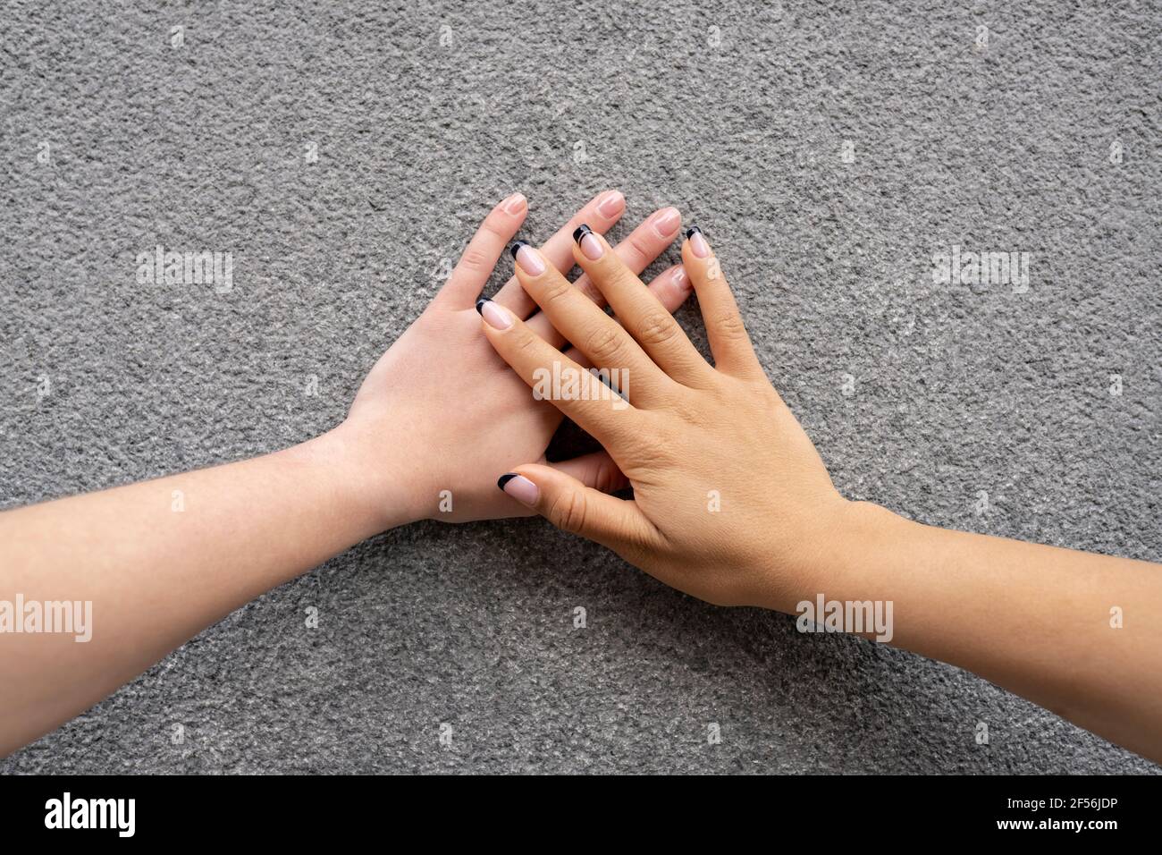 Hands of two young women touching each other Stock Photo - Alamy