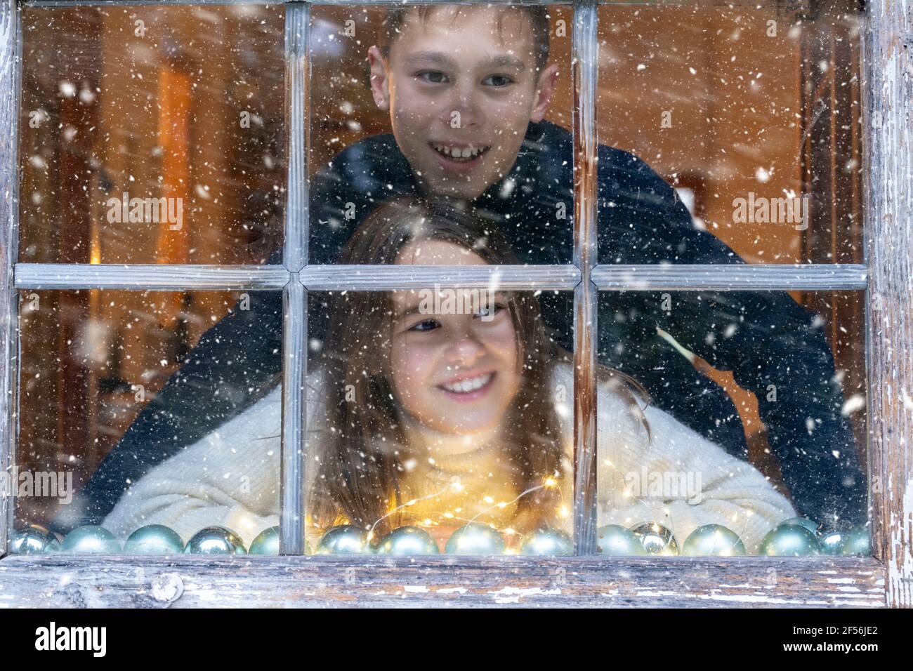 Boy looking through window christmas hi-res stock photography and ...