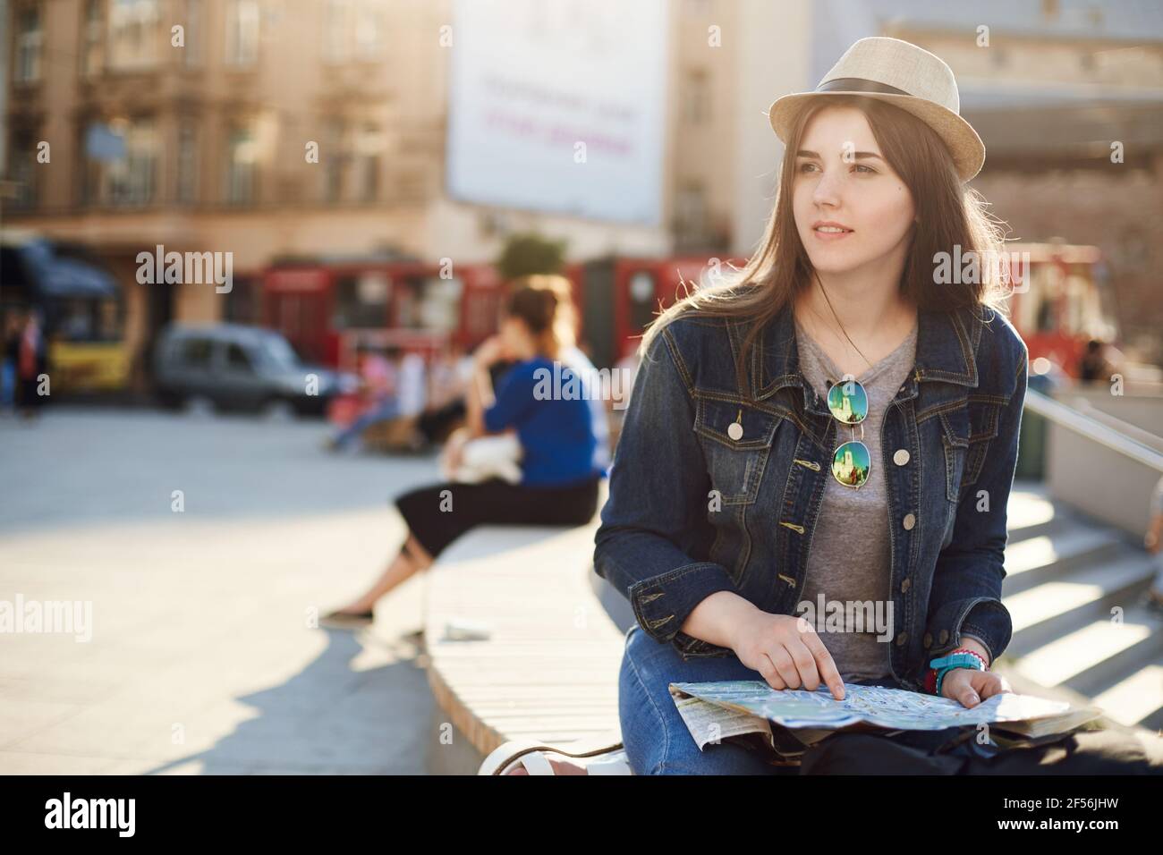 Young woman reading a map lost in the city looking of camera. Travel ...