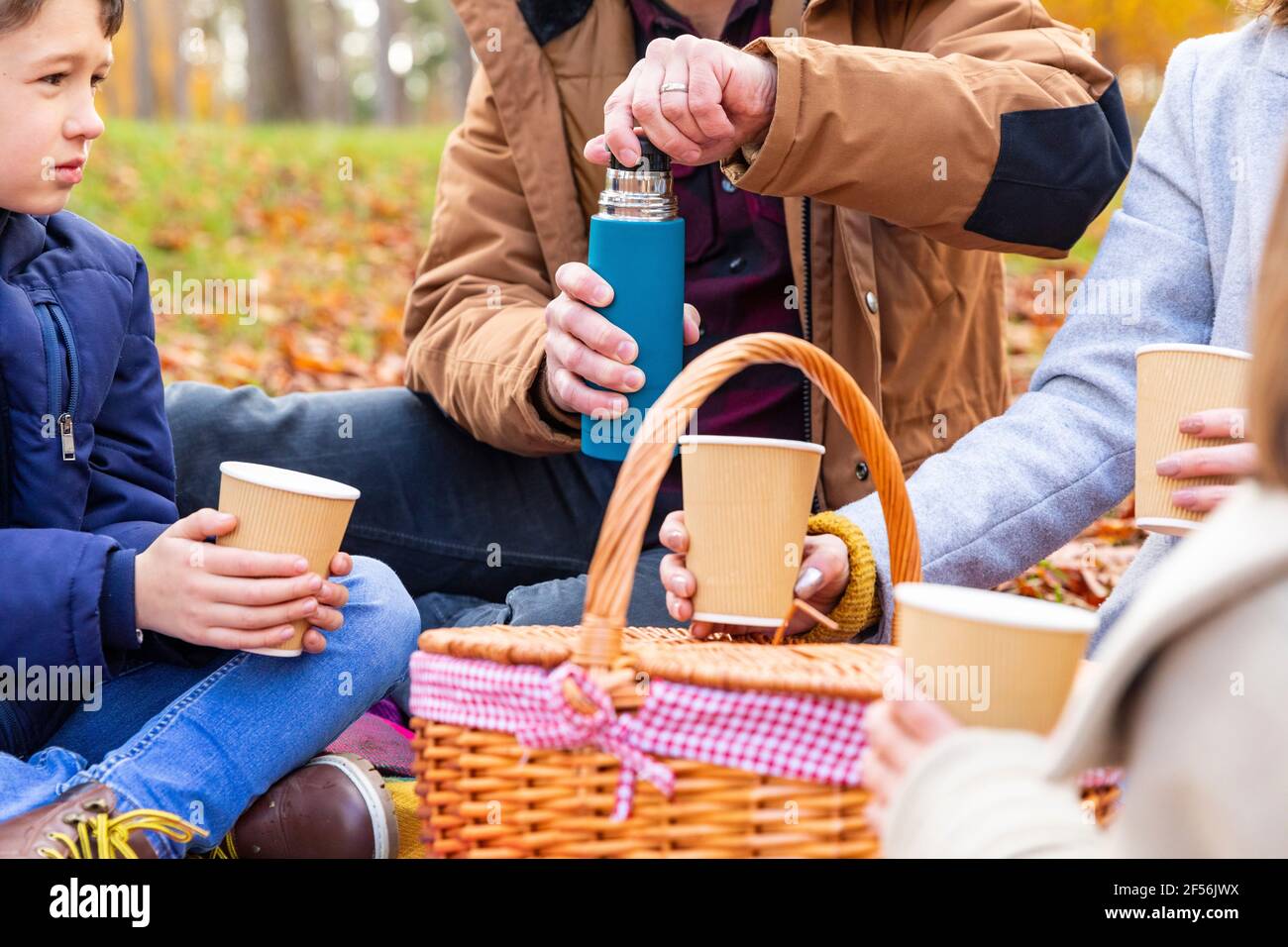 Family having coffee while sitting together in forest Stock Photo - Alamy