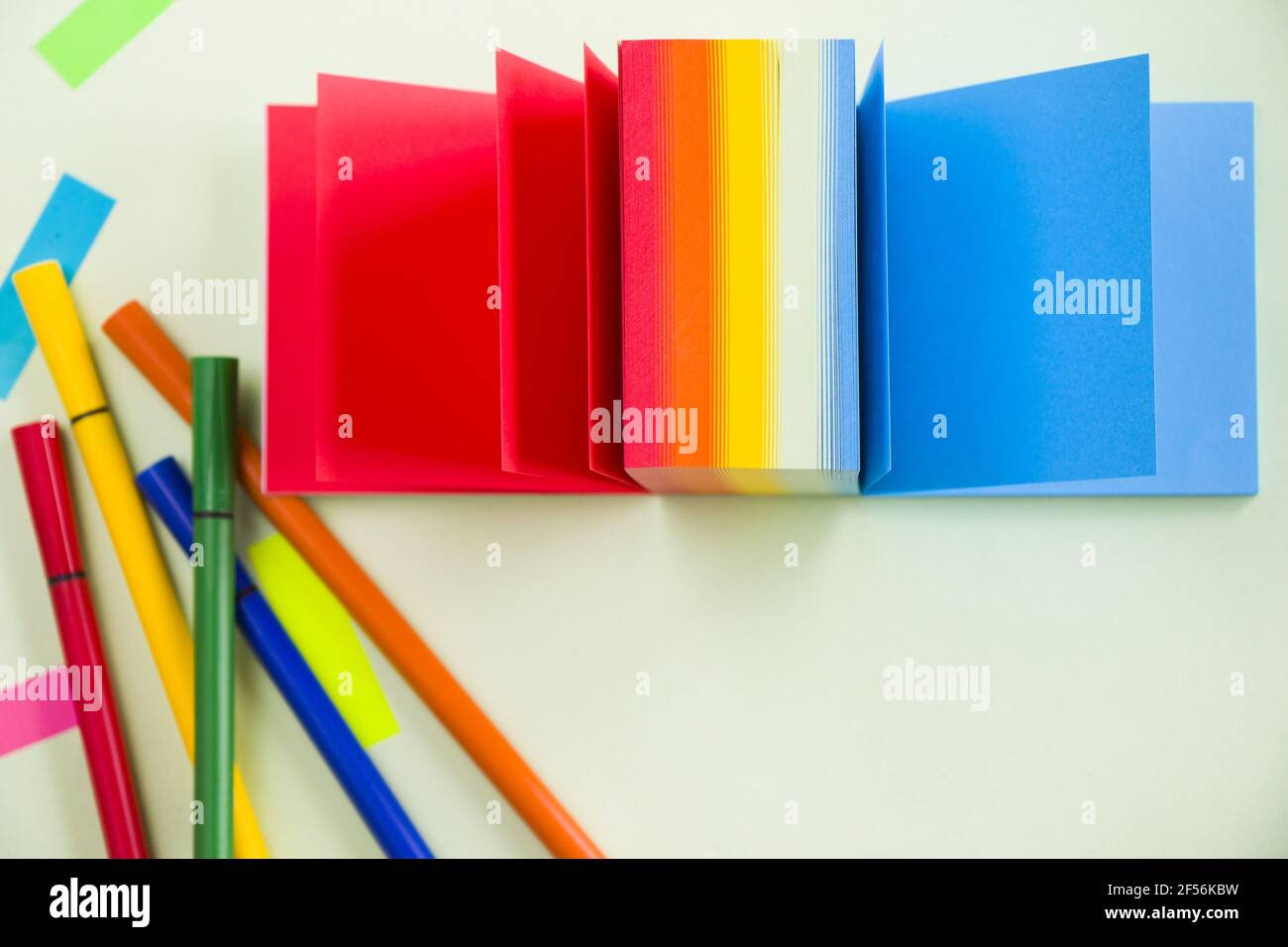 Overhead shot of a set of sketch markers with a colorful notepad with ...
