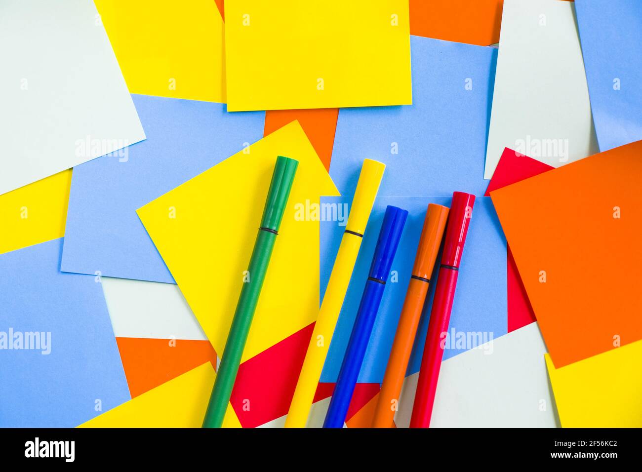 Overhead shot of a set of sketch markers on colorful blank note papers ...