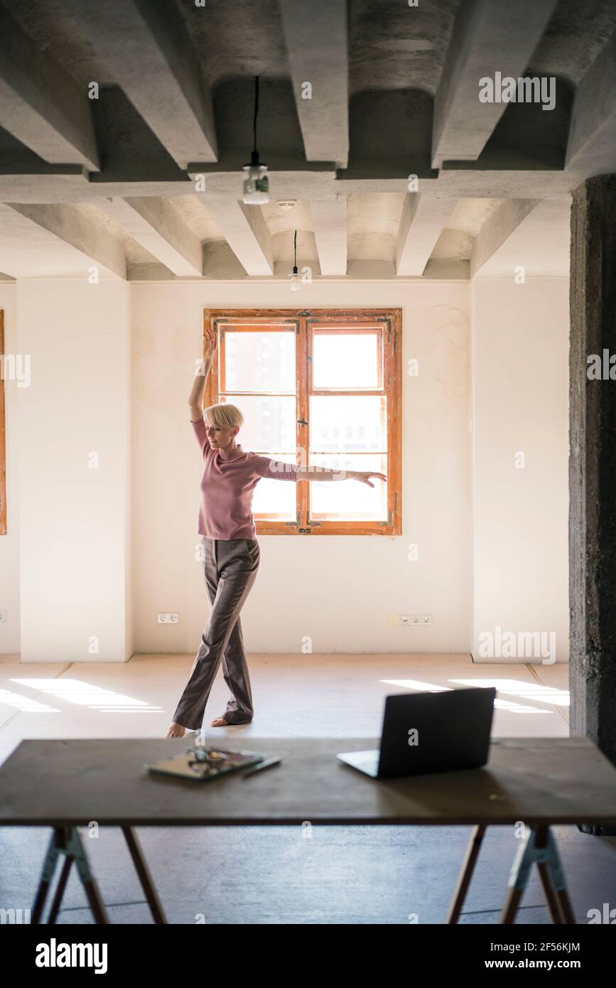 Woman dancing against window in loft apartment Stock Photo - Alamy