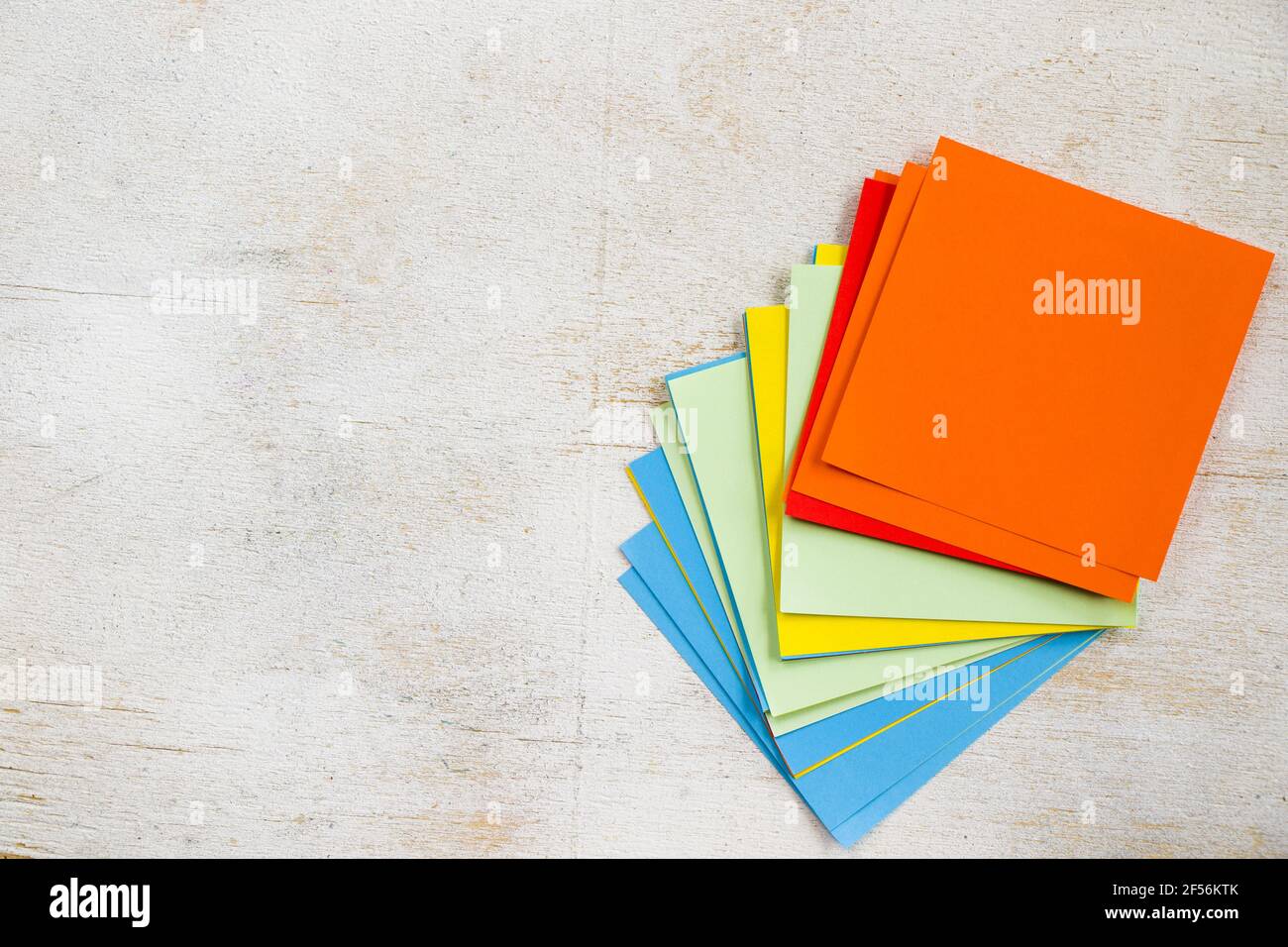 Overhead shot of a stack of colorful notepad on a white surface with ...