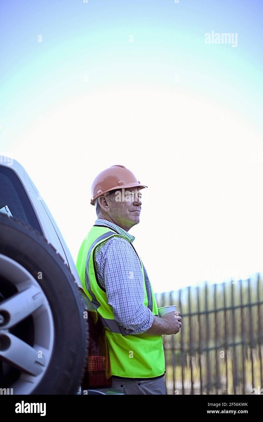 Construction worker taking break by car Stock Photo - Alamy