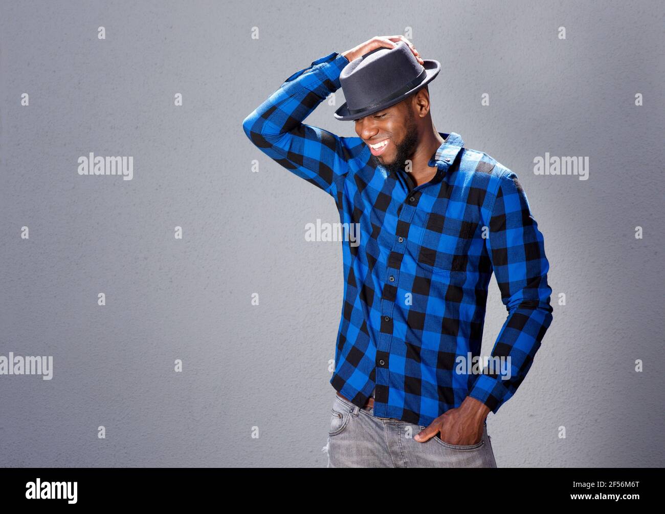 Portrait of happy handsome man laughing with hand to hat Stock Photo ...