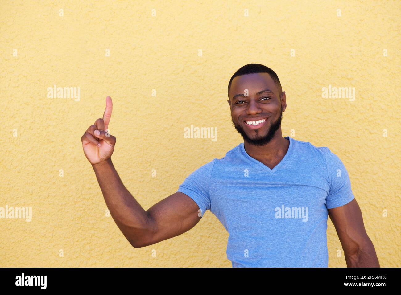 Portrait of confident smiling man pointing finger up Stock Photo - Alamy