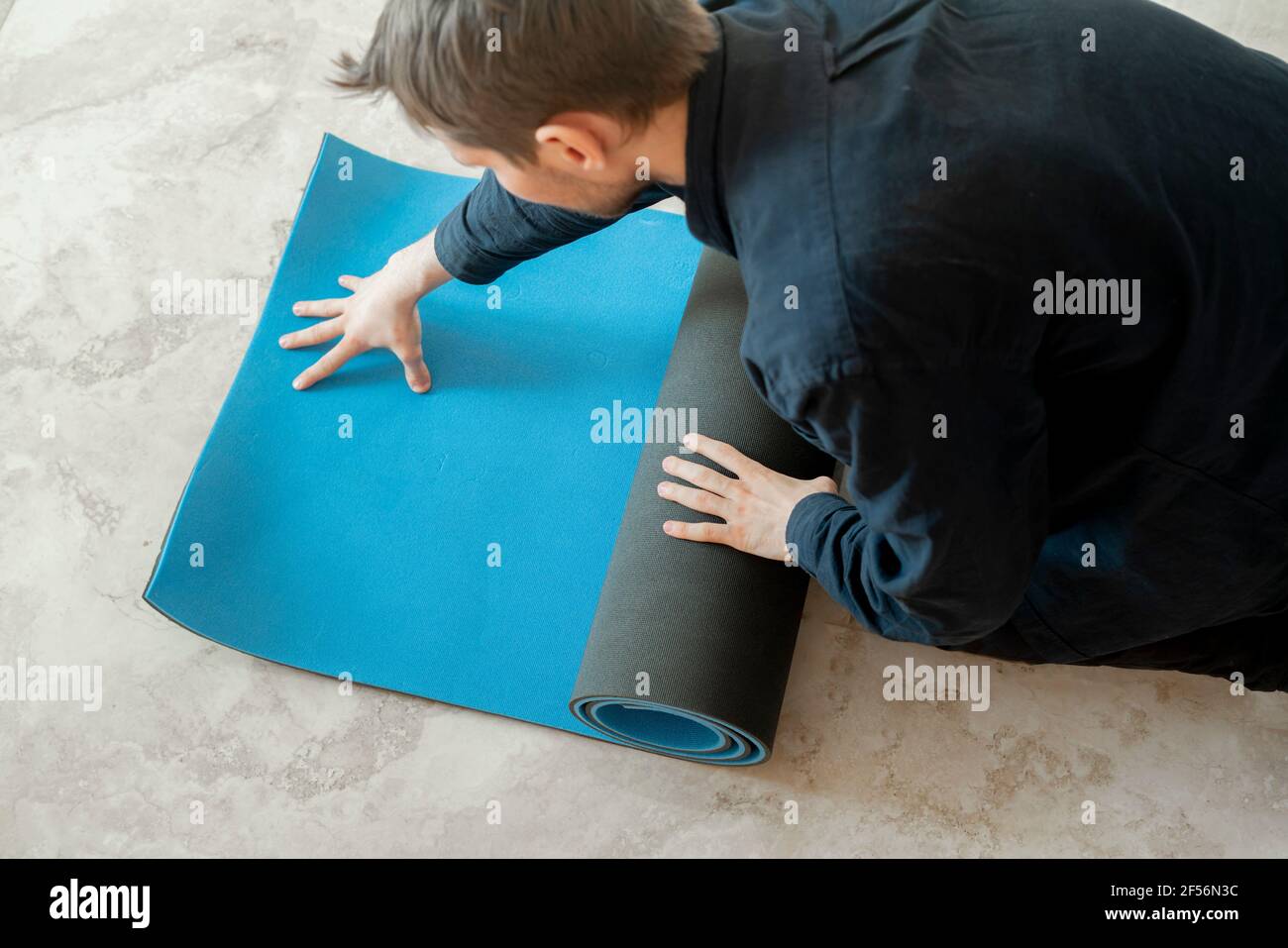 a man rolling the yoga mat on the floor in yoga class workout Stock ...