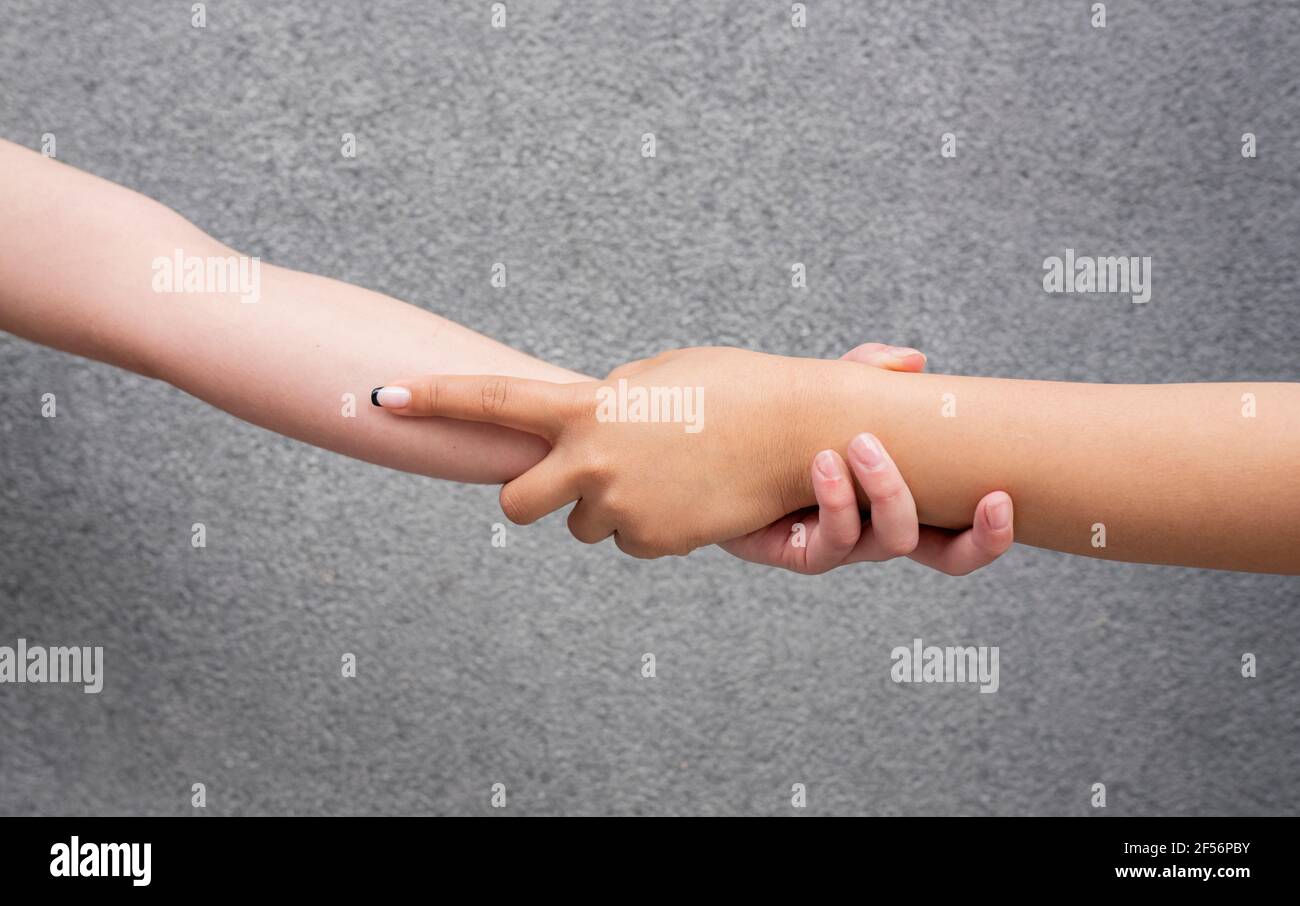 Studio shot of interconnected hands of two young women Stock Photo - Alamy