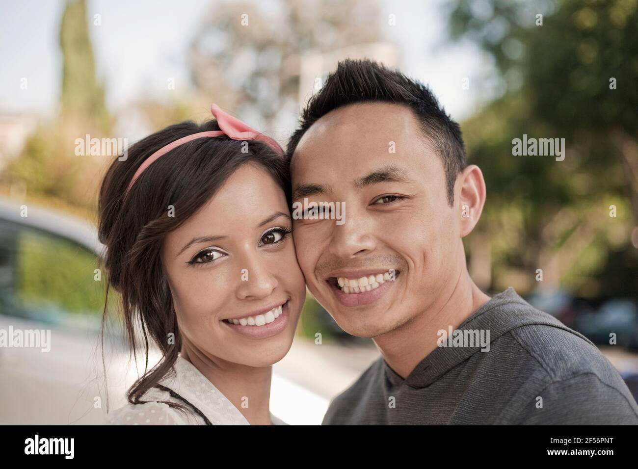 Smiling couple standing cheek to cheek outdoors Stock Photo - Alamy