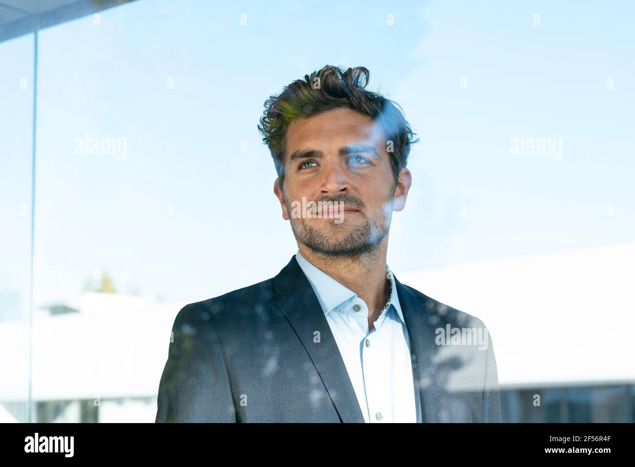 Businessman standing behind glass hi-res stock photography and images ...
