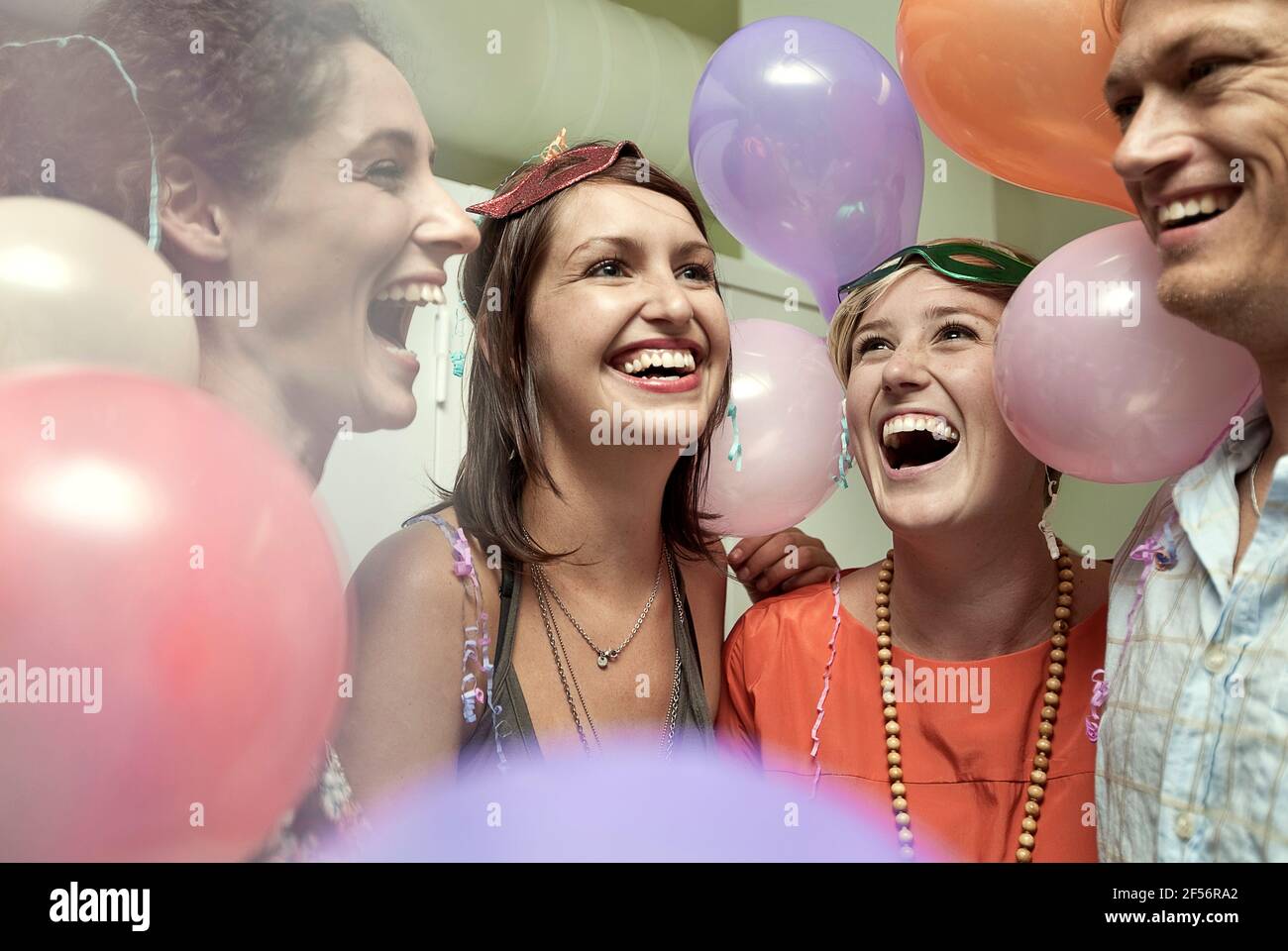 Friends smiling while standing together at party Stock Photo - Alamy