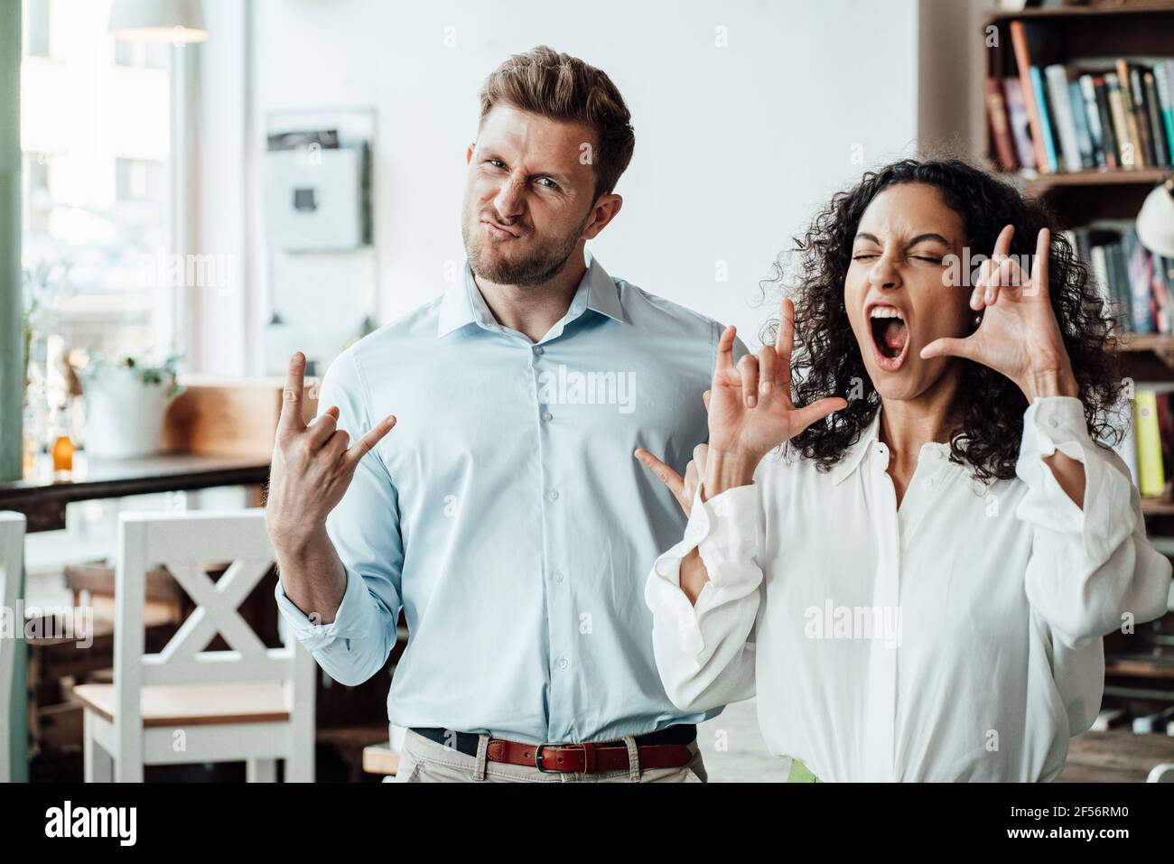 Business people gesturing hand signs while standing at cafe Stock Photo ...