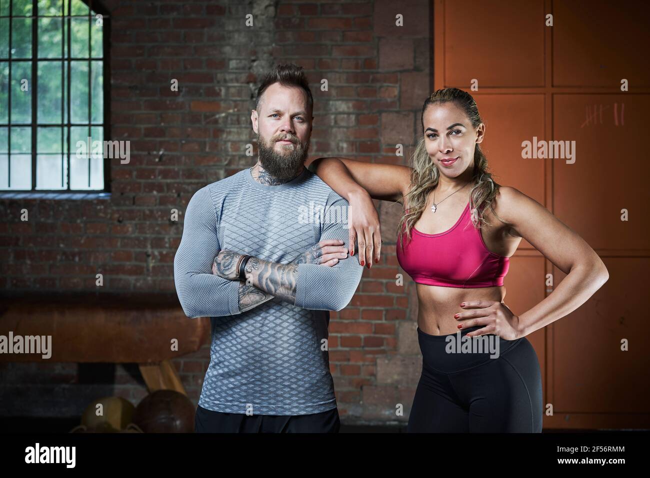 Confident male and female fitness instructors in gym Stock Photo - Alamy