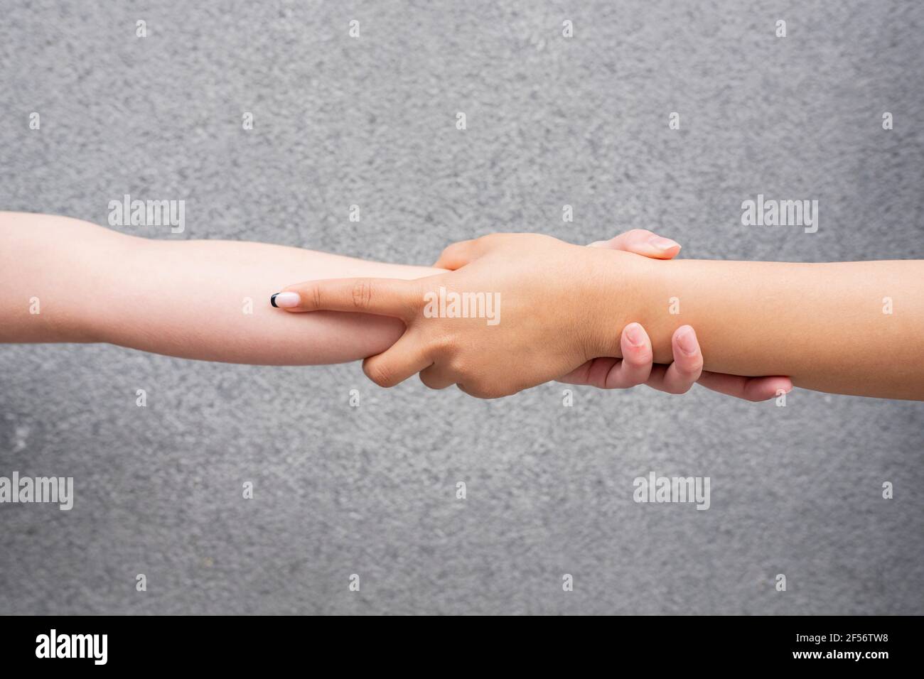 Studio shot of interconnected hands of two young women Stock Photo - Alamy