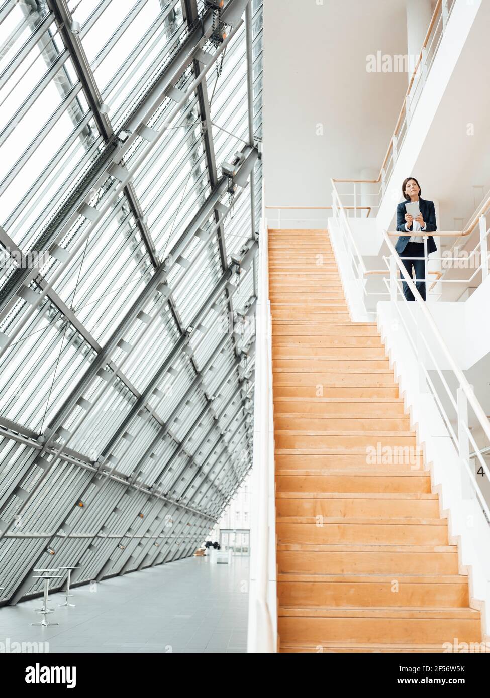 Female professional standing by railing over steps at office Stock ...