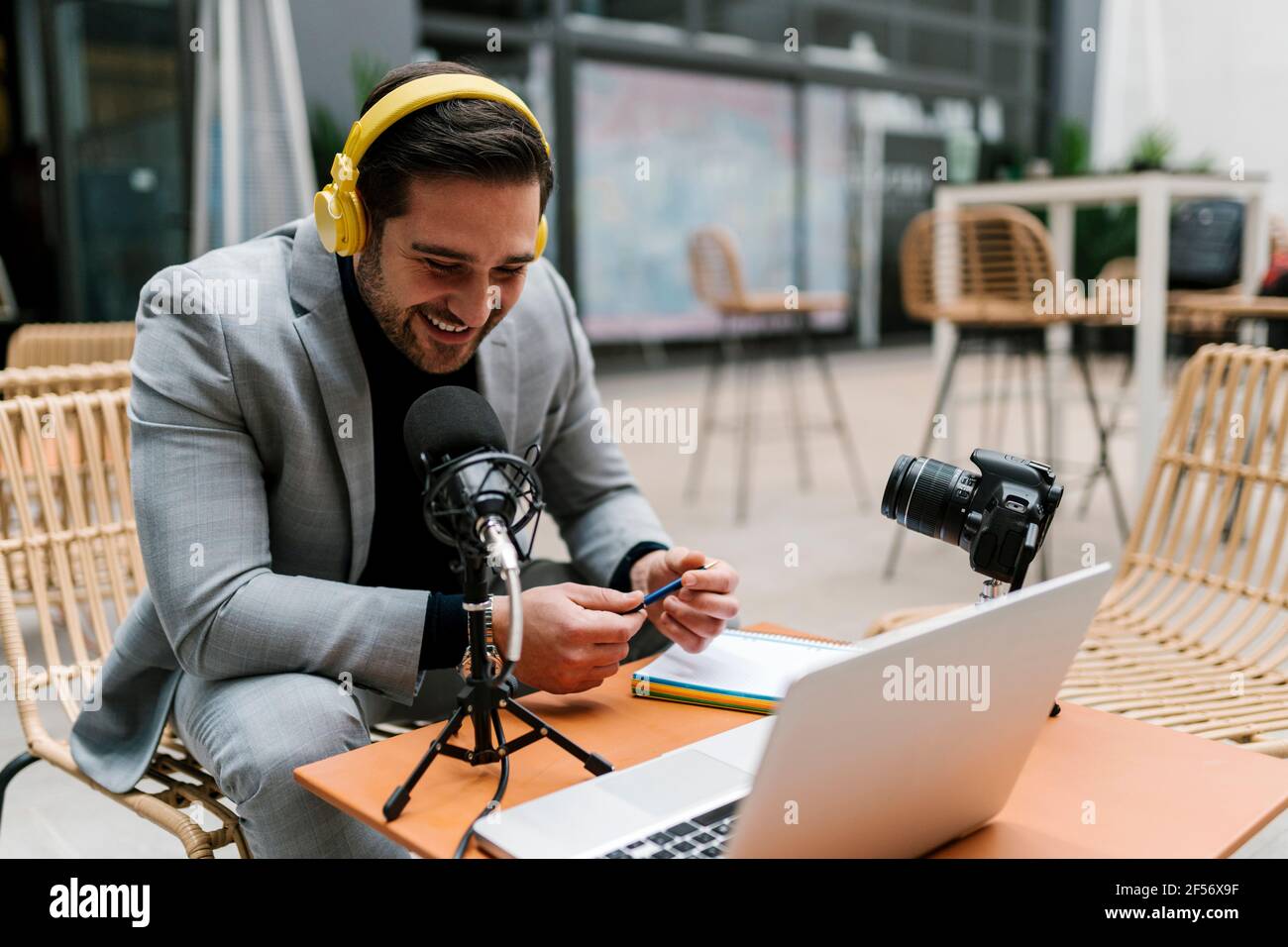 Smiling businessman using microphone while vlogging at cafe Stock Photo ...
