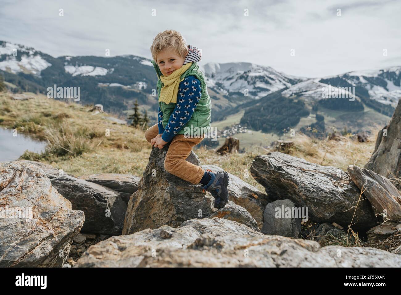 Smiling boy sitting rock sky salzburger land hi-res stock photography ...