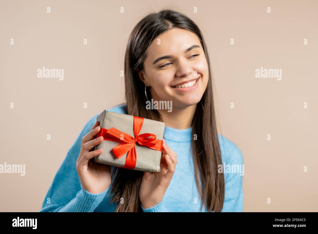 Excited woman received gift box with bow. She is happy and flattered by ...