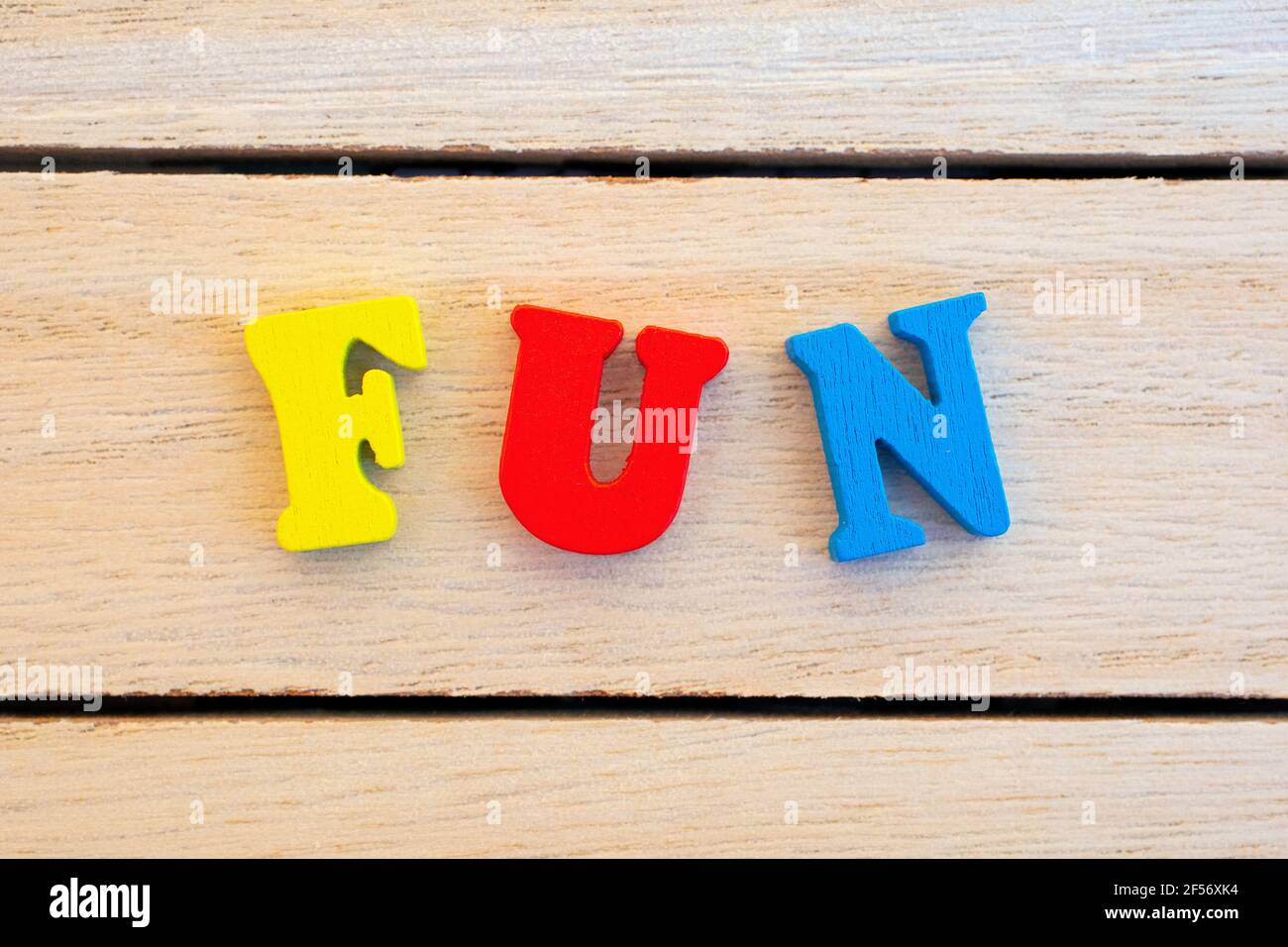 The word FUN spelt with colourful wooden letters Stock Photo - Alamy