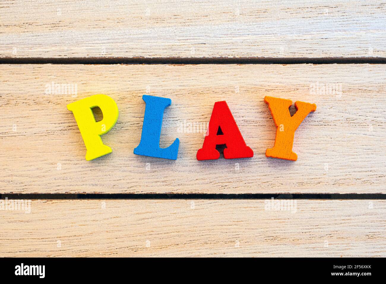The word PLAY spelt with colourful wooden letters Stock Photo - Alamy