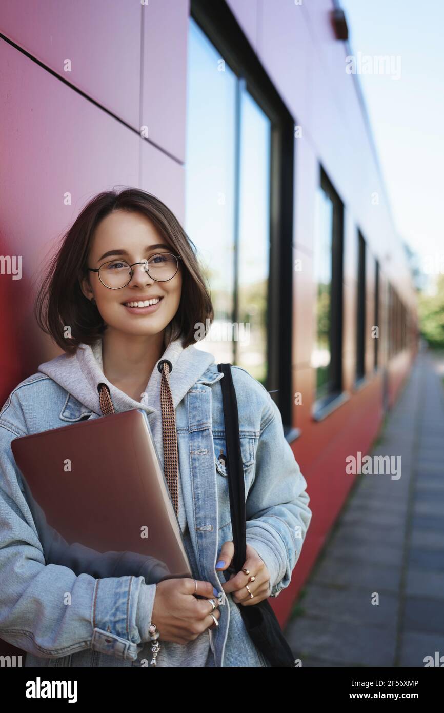 Vertical portrait of happy dreamy young female student look away with ...
