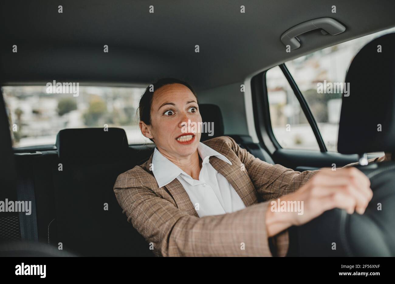 Scared businesswoman in back seat of car Stock Photo - Alamy