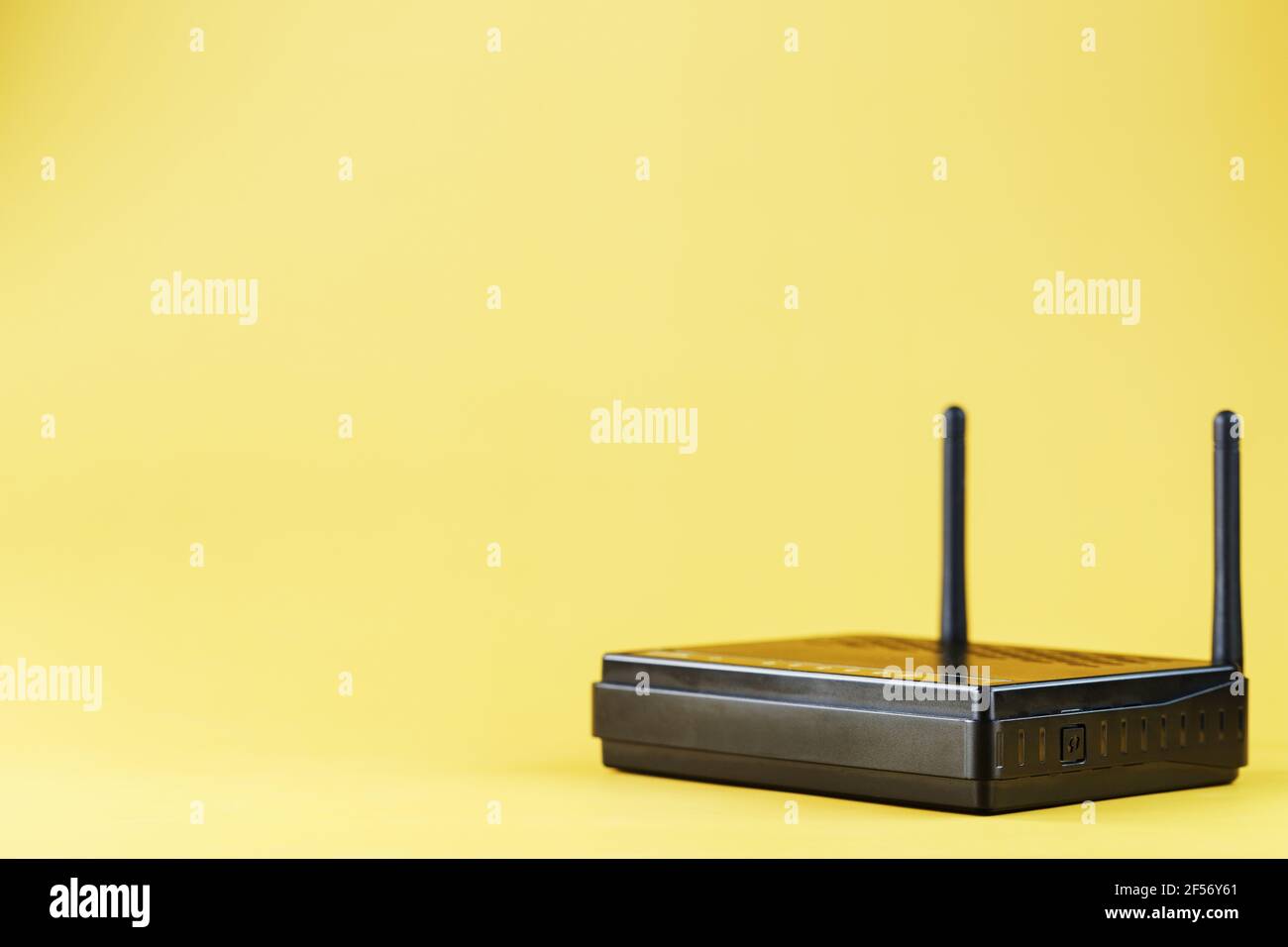Black Wi-Fi router on a yellow background with free space. Isolate, top ...