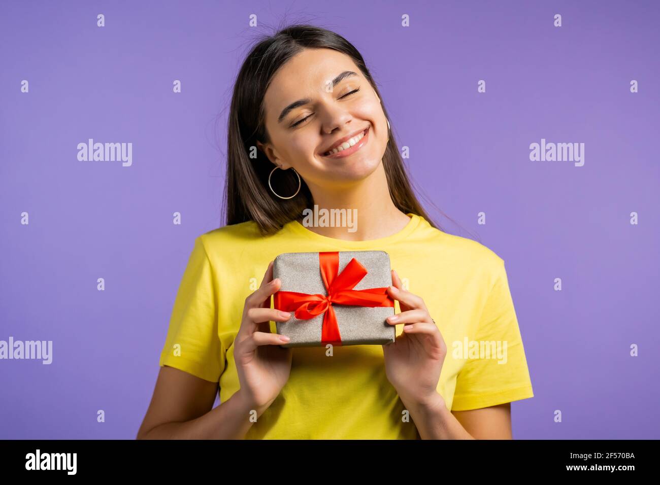 Beautiful woman received gift box with bow. She is happy and flattered ...