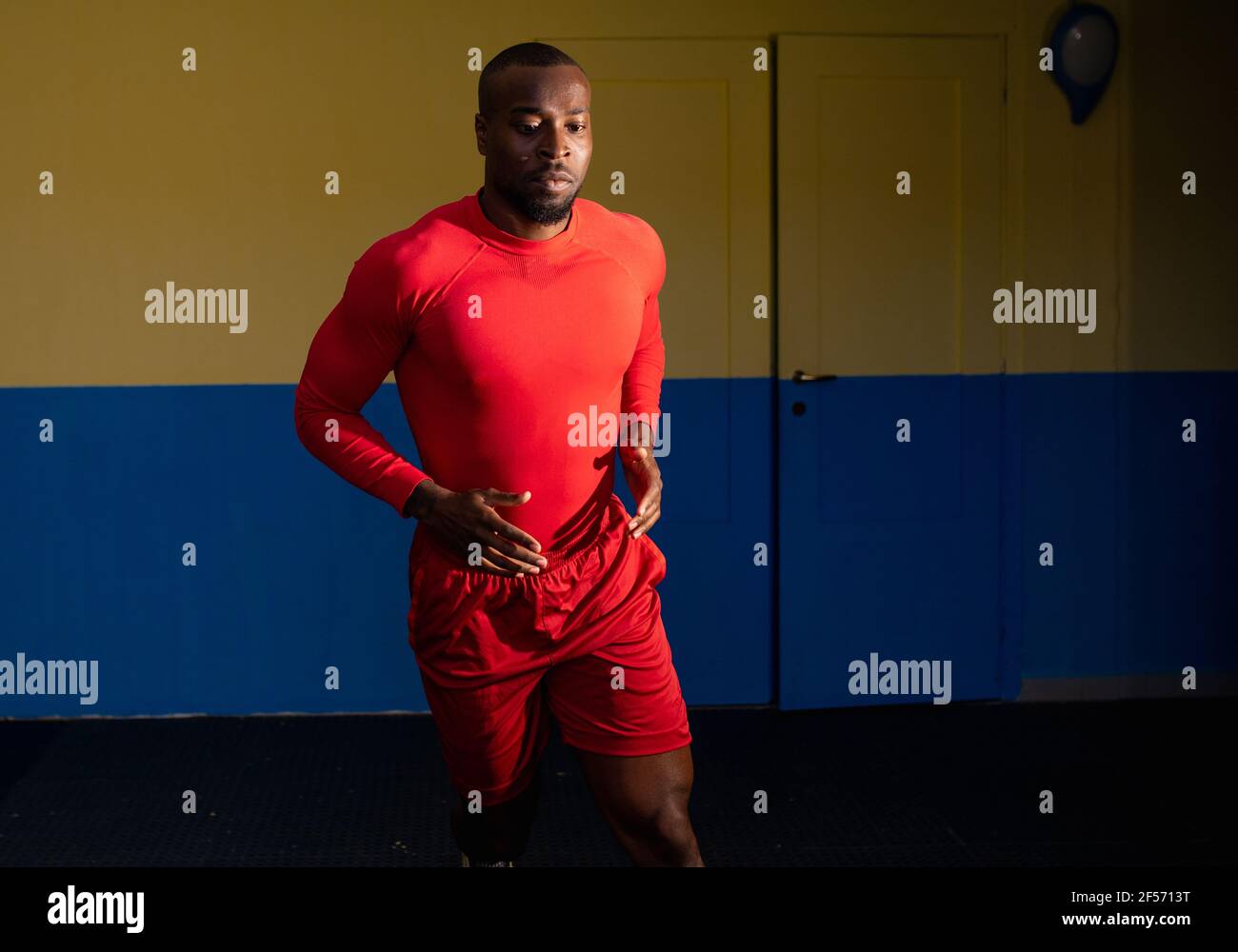 Black sportsman inside stadium arena with dim lights waiting before ...