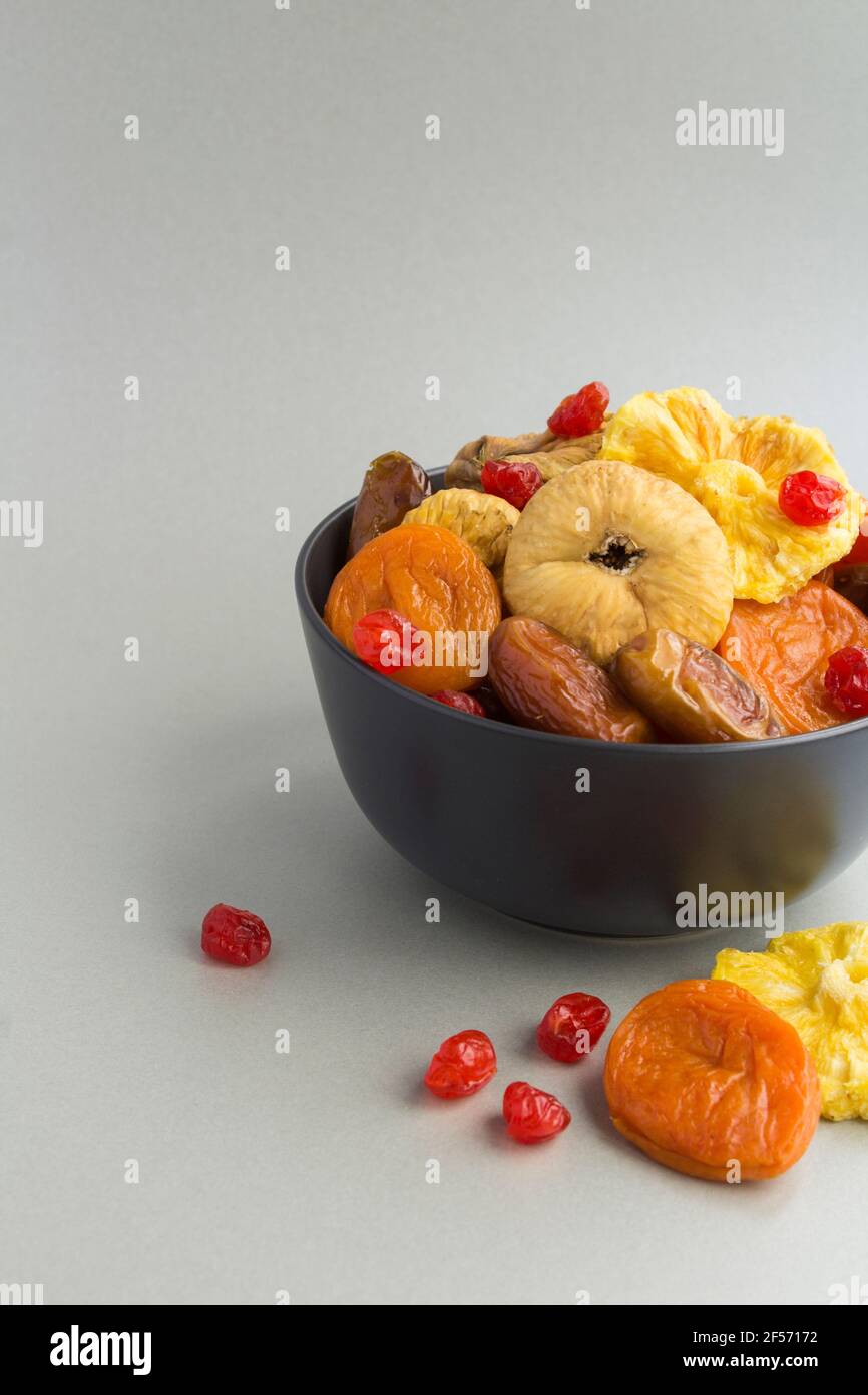 Closeup on different dried fruits in the black bow on the gray ...