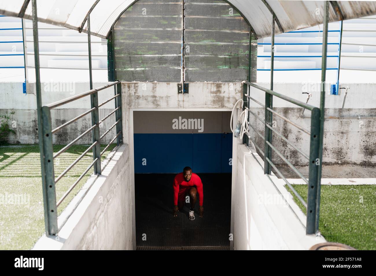Professional runner inside stadium prepare to start running in position ...