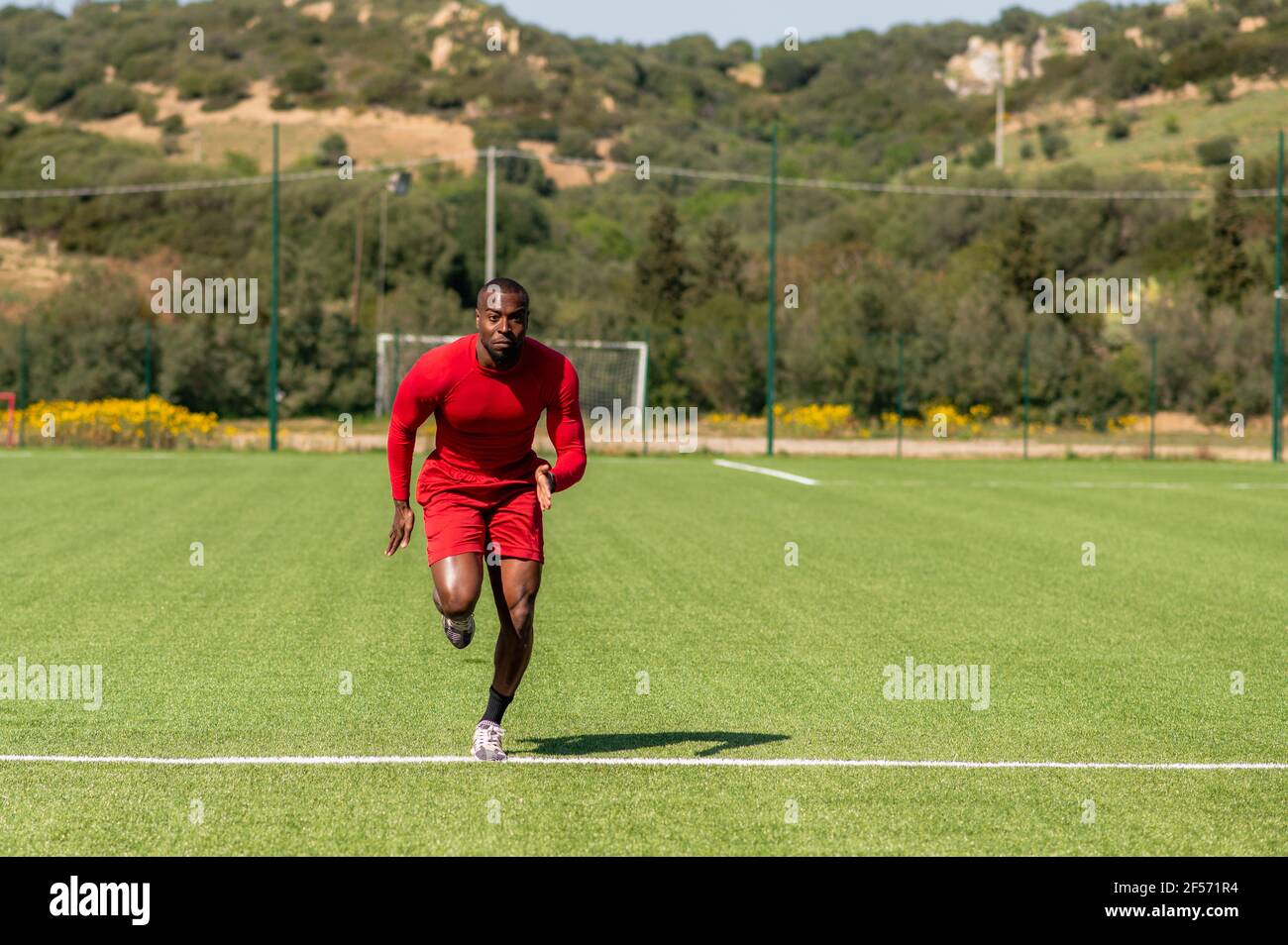 Wide angle African sportsman running fast in a football field Stock ...