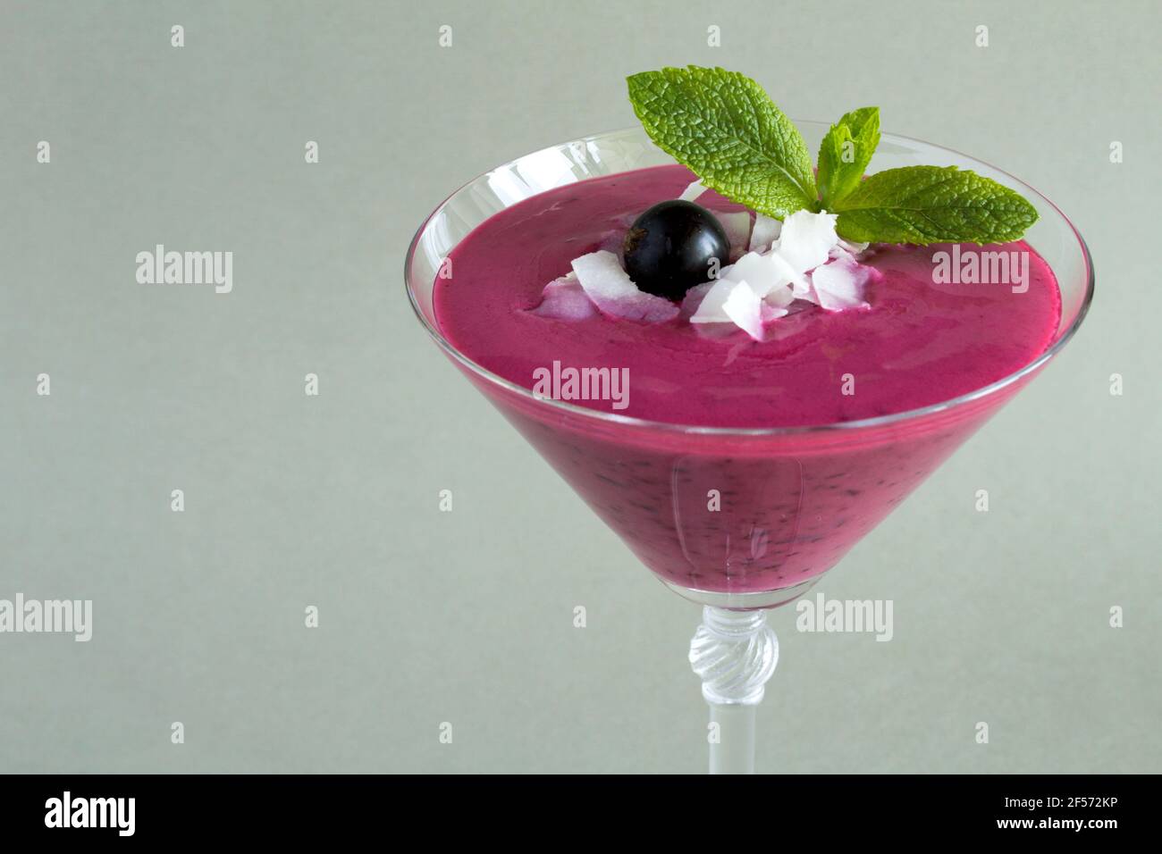 Indian drink lassi with black currant in the glass on the grey ...