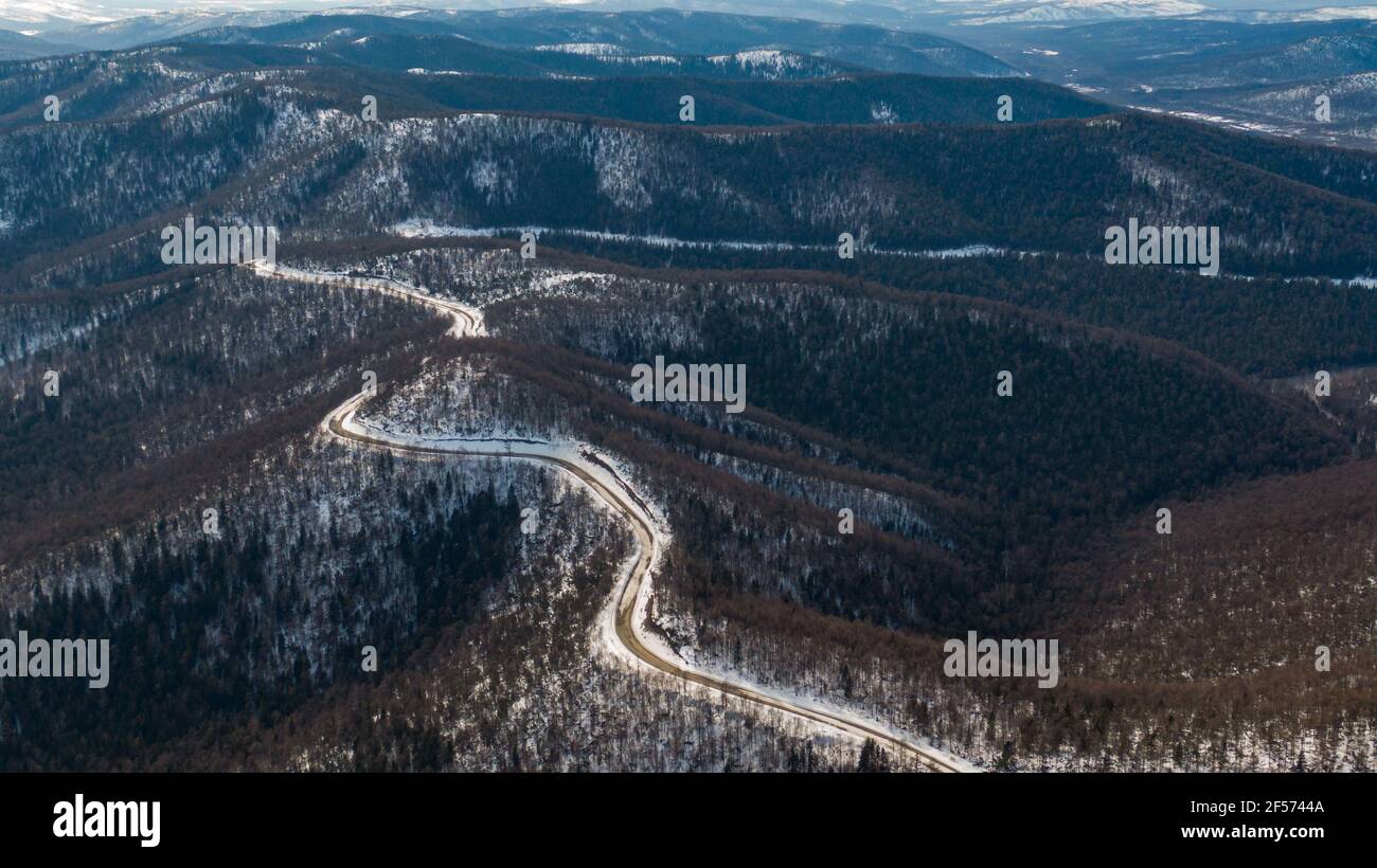 Aerial view of the river and taiga forests and road in the winter ...