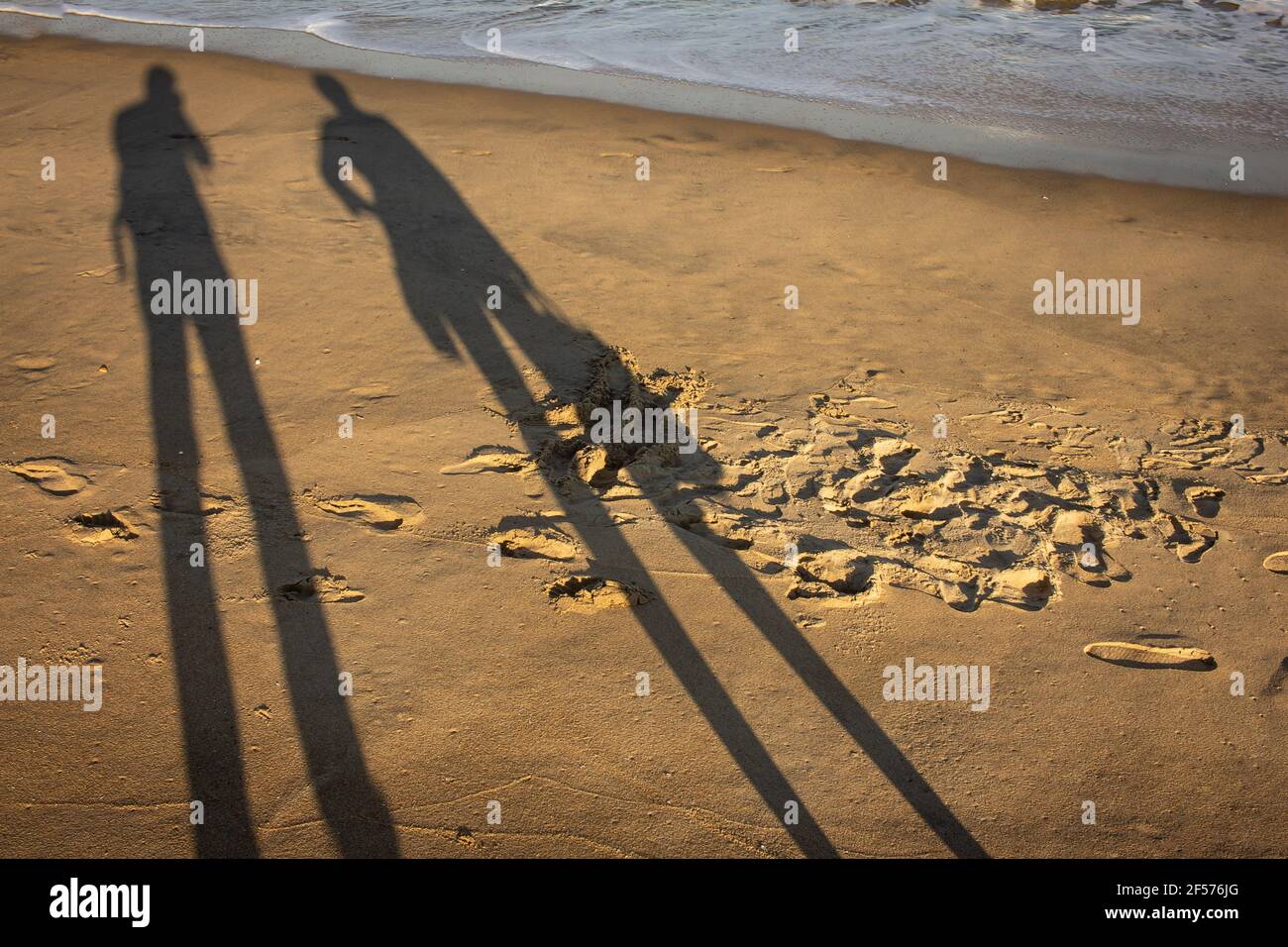 Shadow of a couple over the beach sand in Mahabalipuram. Couple's ...