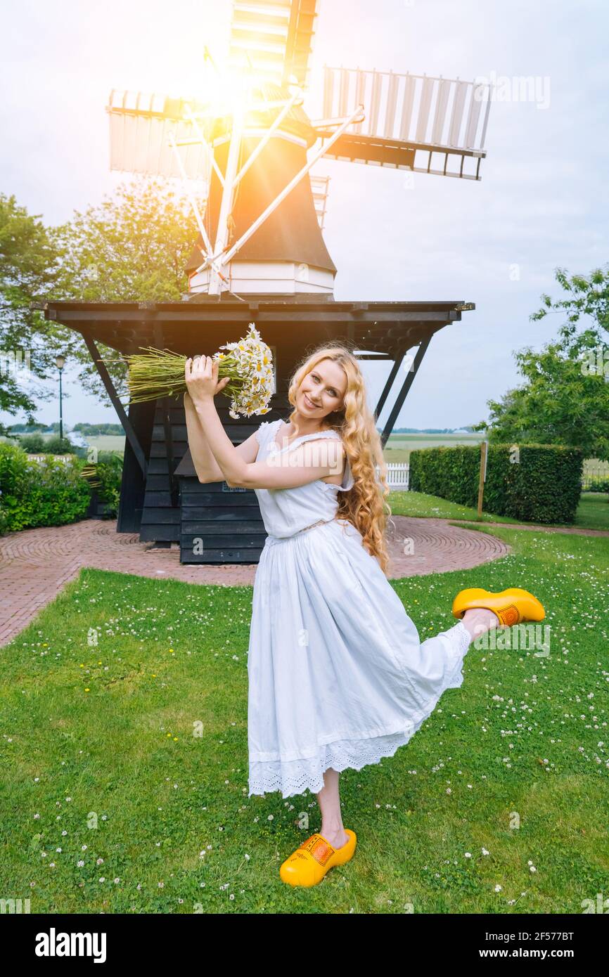 Woman dressed on traditional Dutch dress, wooden shoes yellow clogs ...