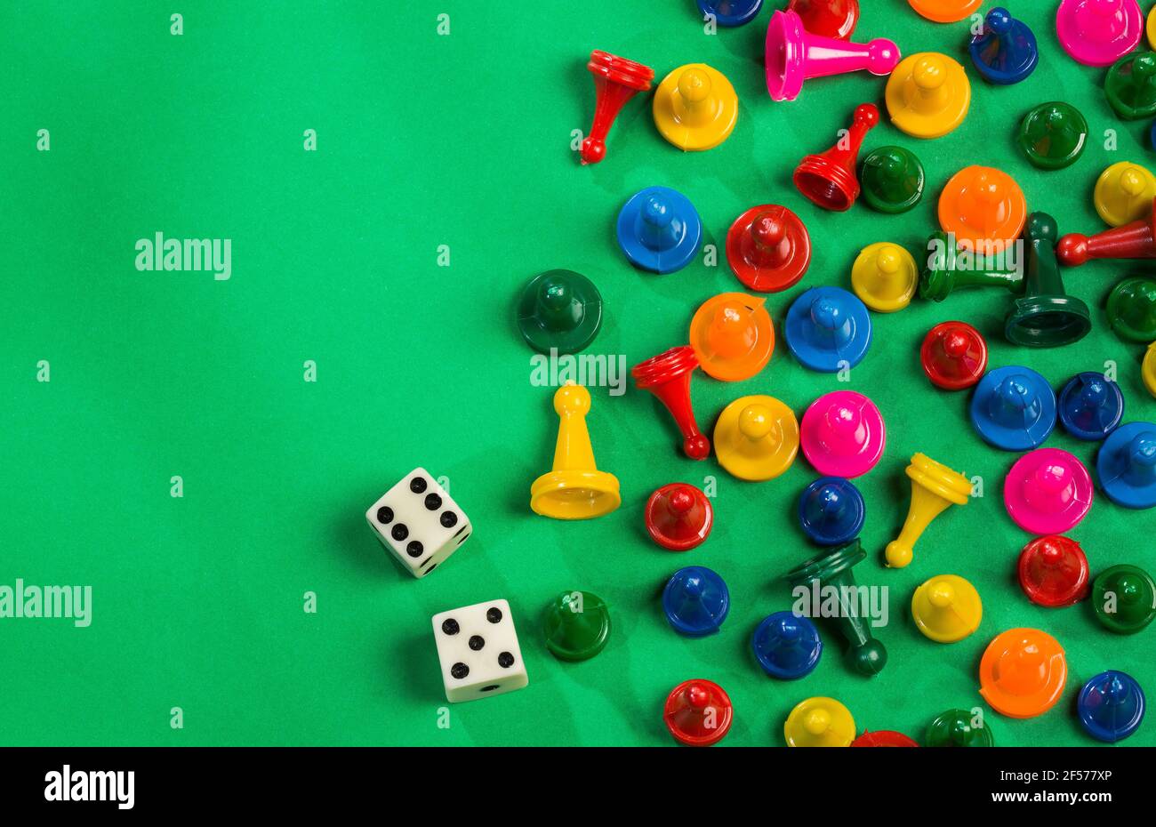 Game pieces of different colors and dice Stock Photo - Alamy