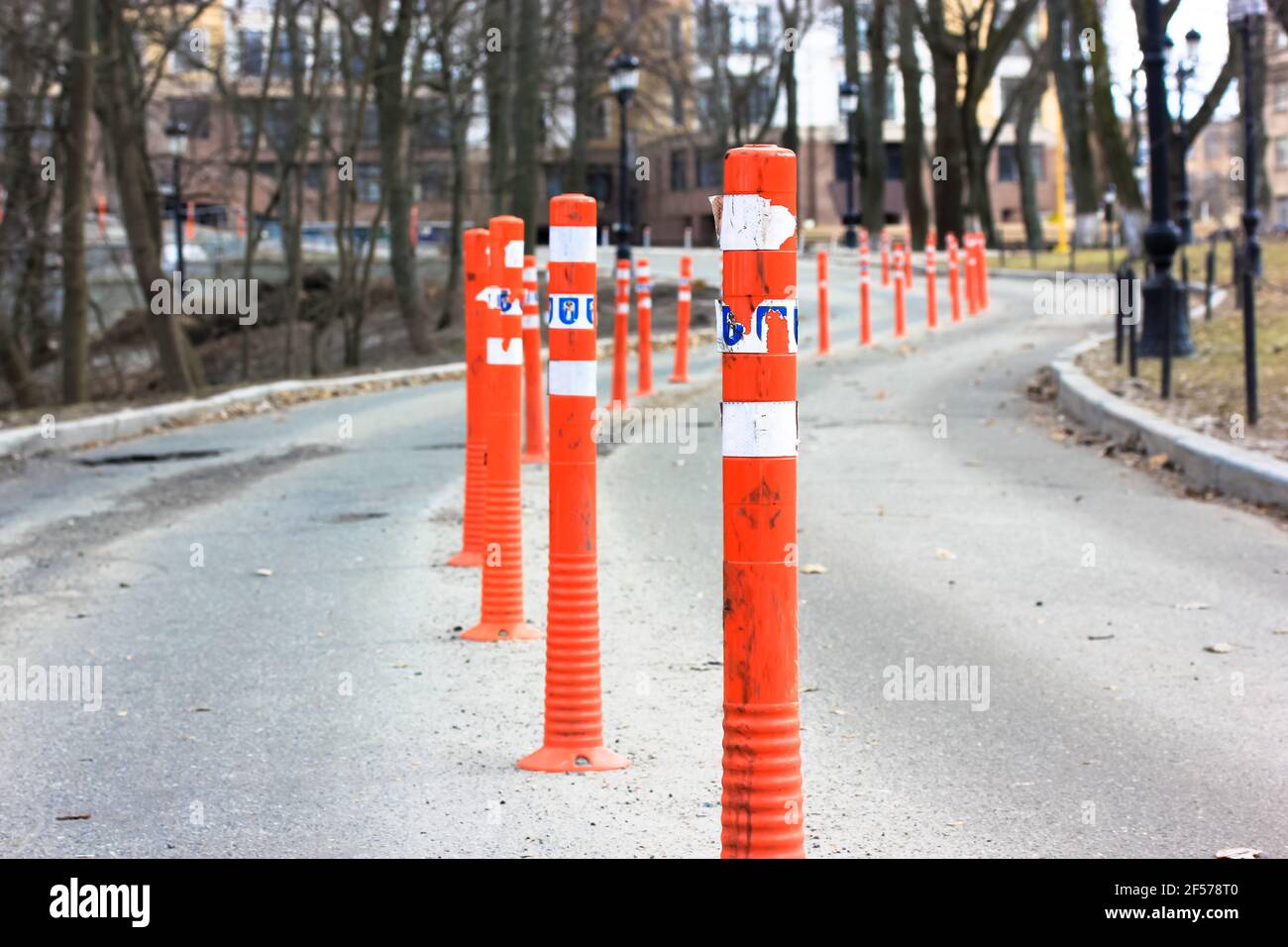 A line of flexible safety PVC delineators, orange plastic road poles ...