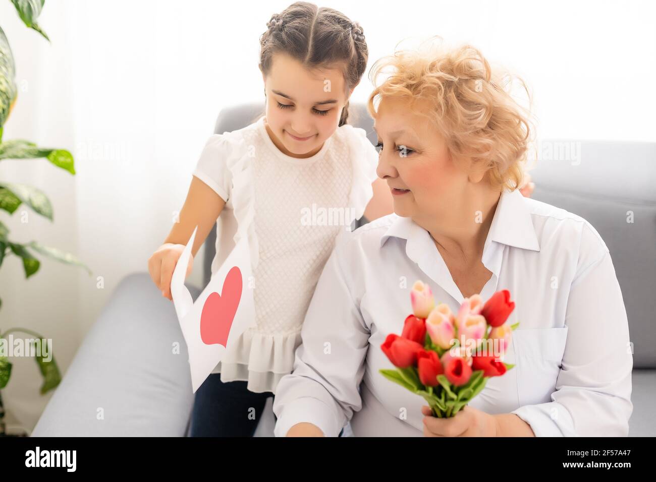Sincere cute little granddaughter strong cuddling and kissing in cheek ...