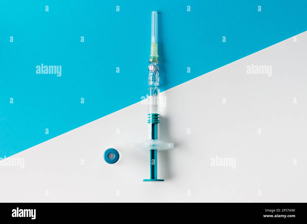 Syringe with medical vial for injection on blue and white background ...