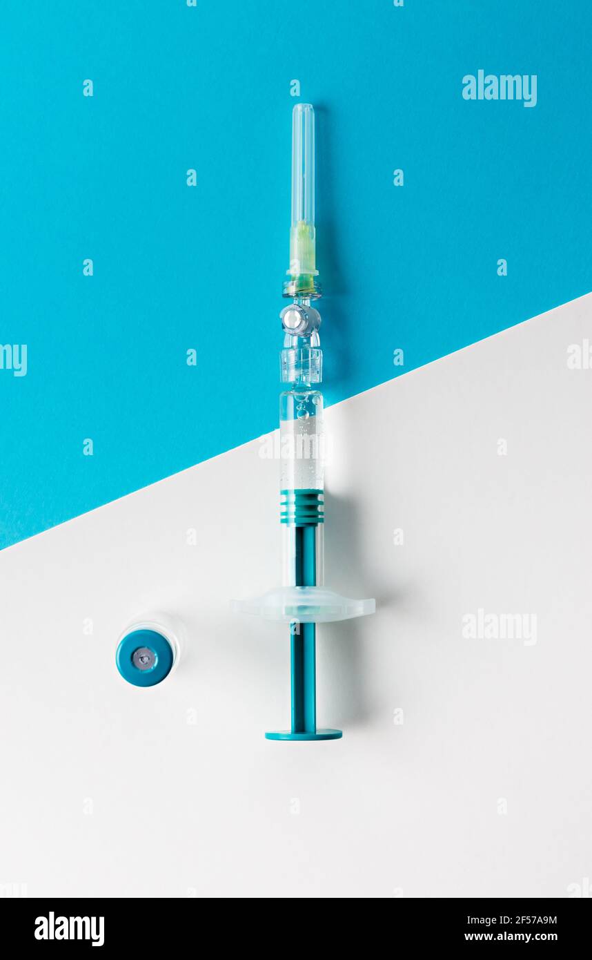 Syringe with medical vial for injection on blue and white background ...