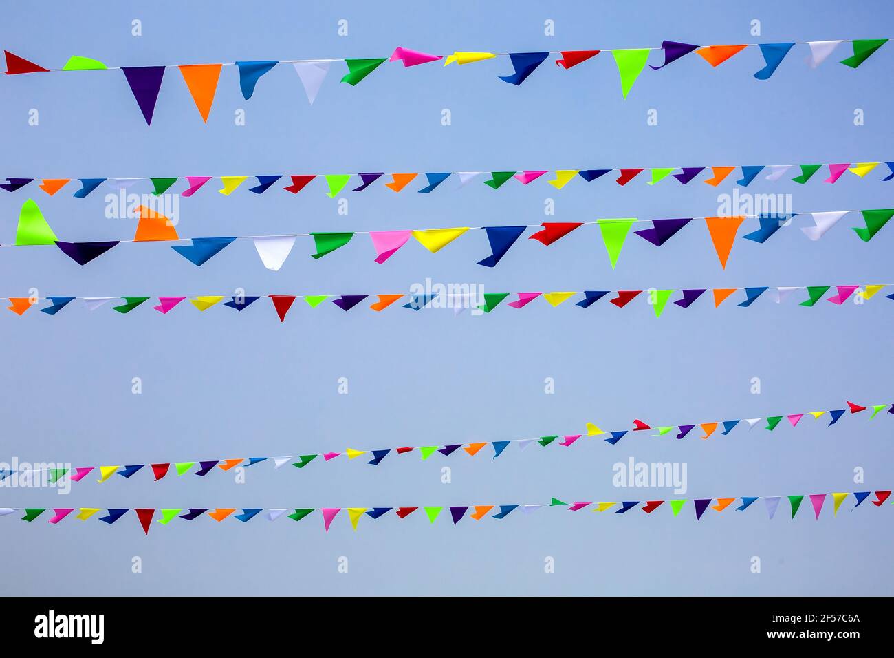 triangular festive multi-colored flags are suspended on a tight rope ...