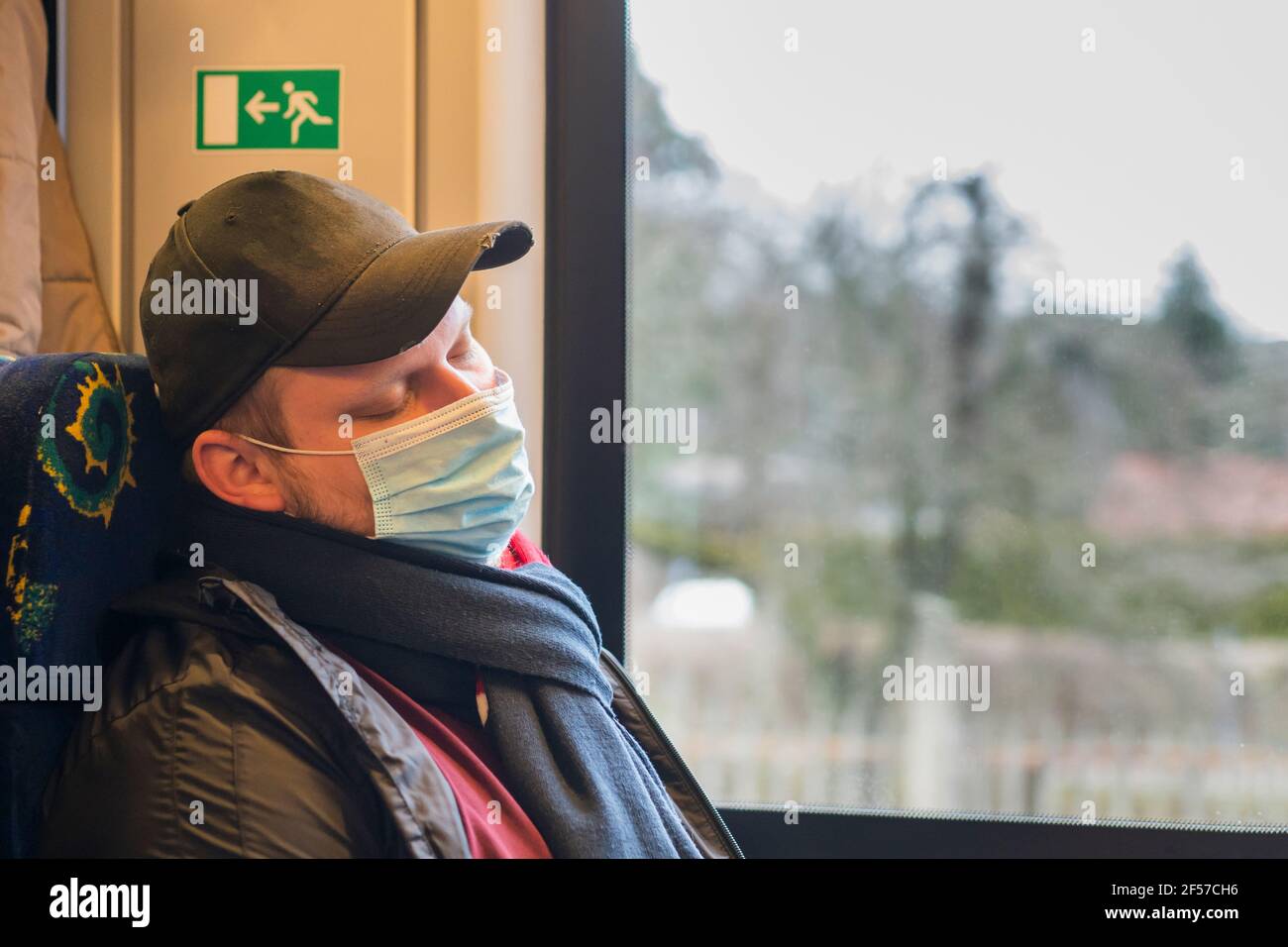 Sleeping man with medical protective mask on train Stock Photo - Alamy